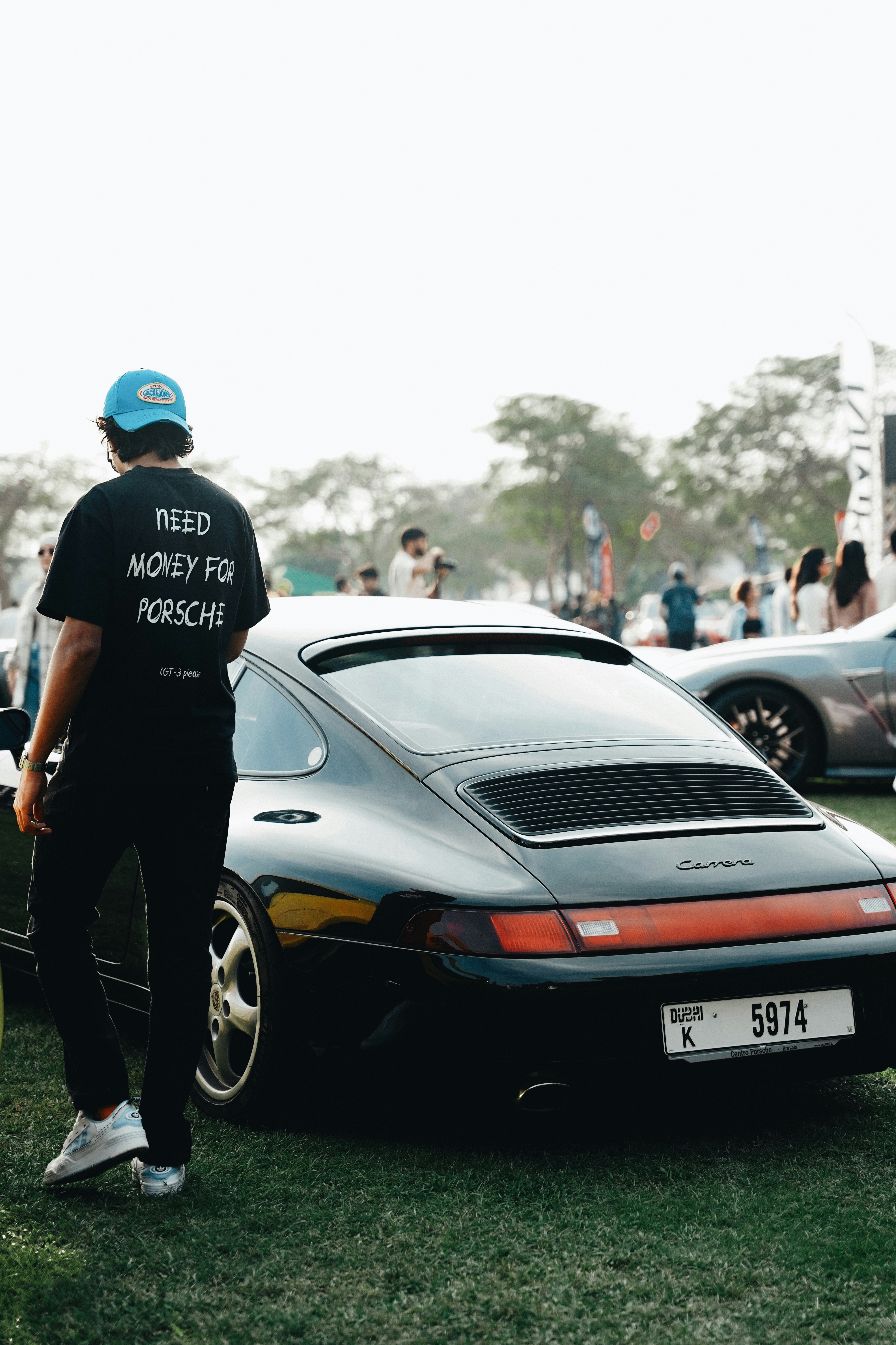 Rear-View Car Show: A Street Scene with a Porsche and Onlookers