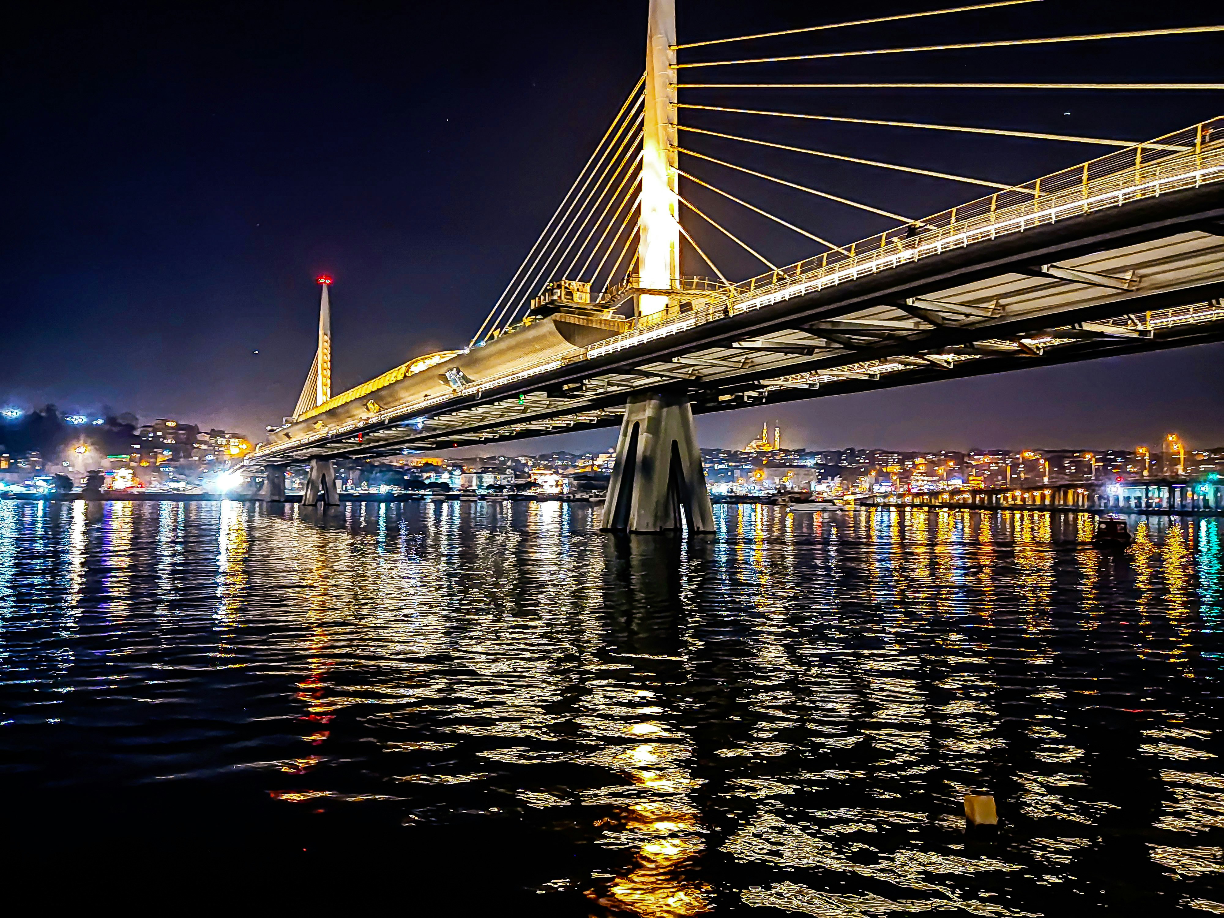 A large bridge over a body of water at night photo – Free Urban Image ...