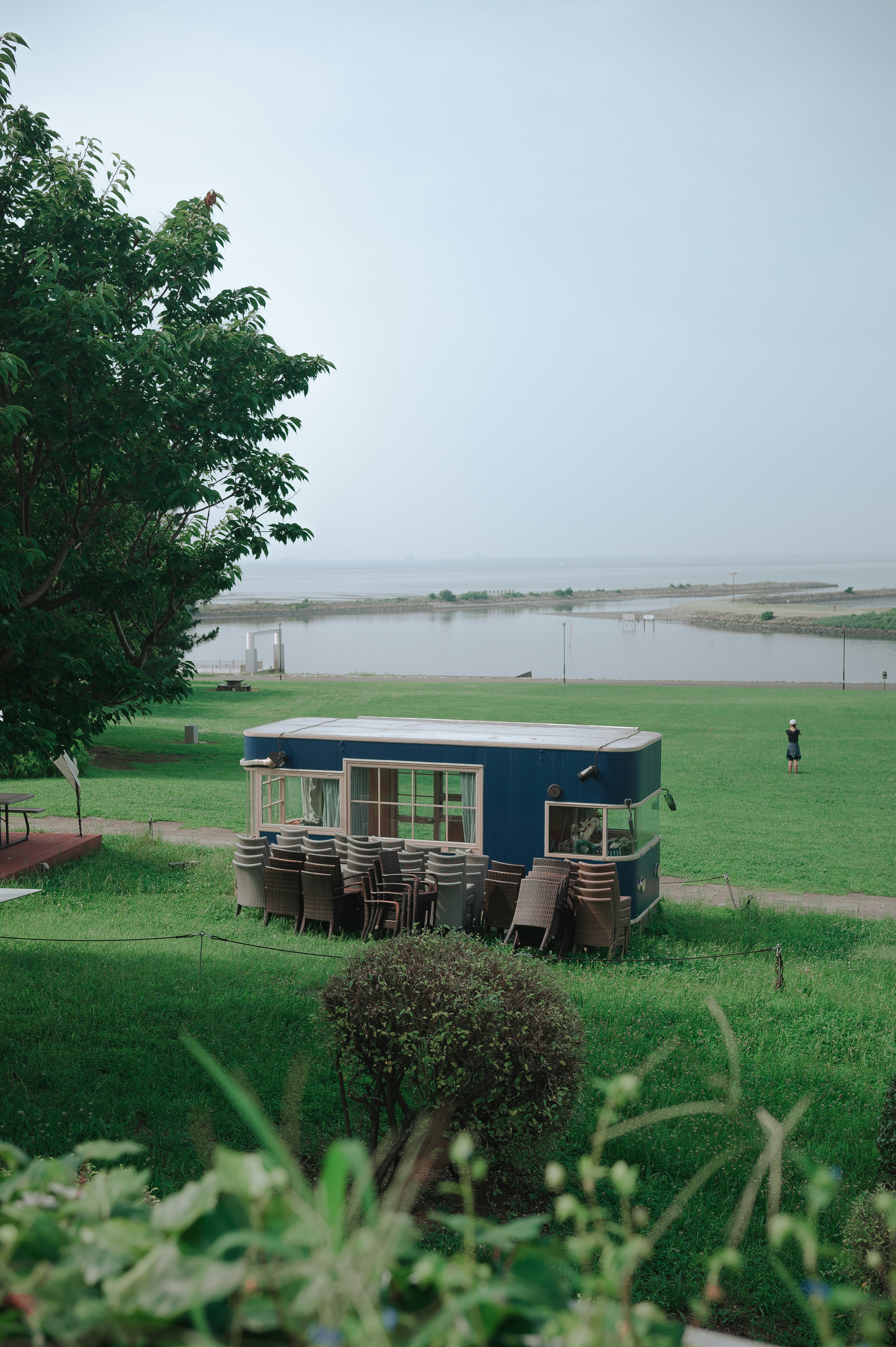 Blue kiosk by the green lawn overlooking a calm shoreline
