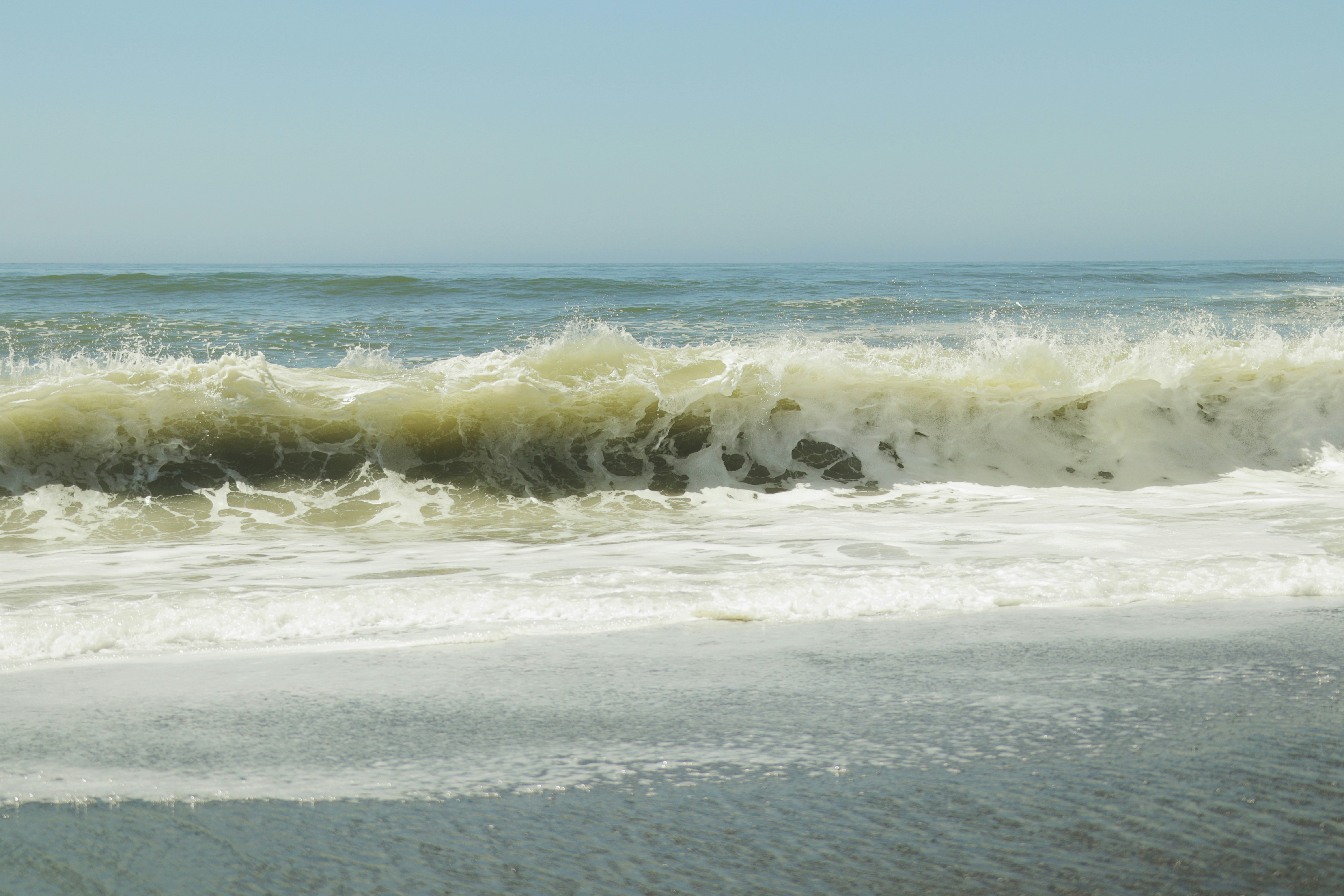 A person riding a surfboard on top of a wave photo – Free Elk Image on ...