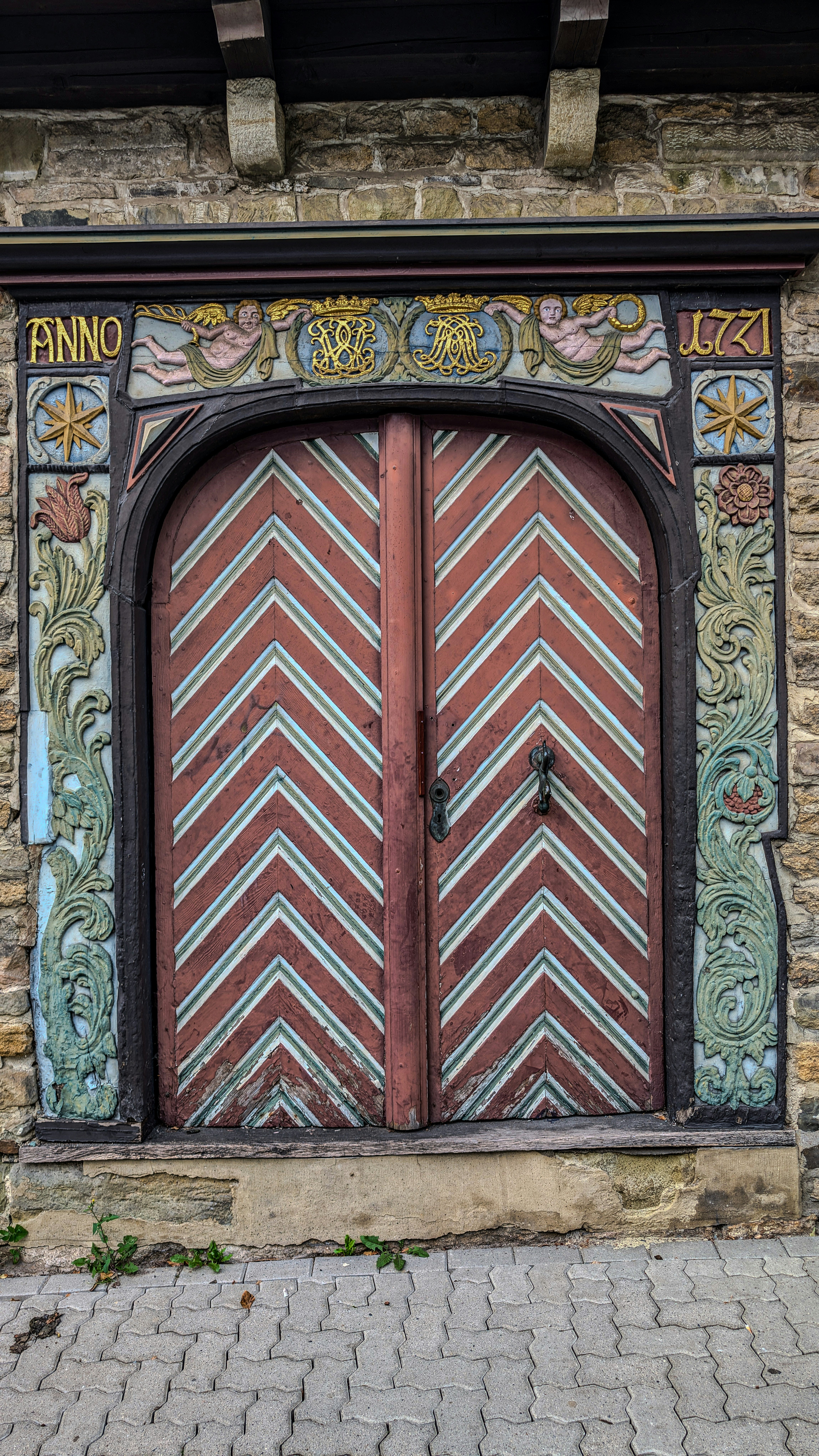 Chevron Gate in Carved Stone: A Historic Doorway Framed by Floral Reliefs