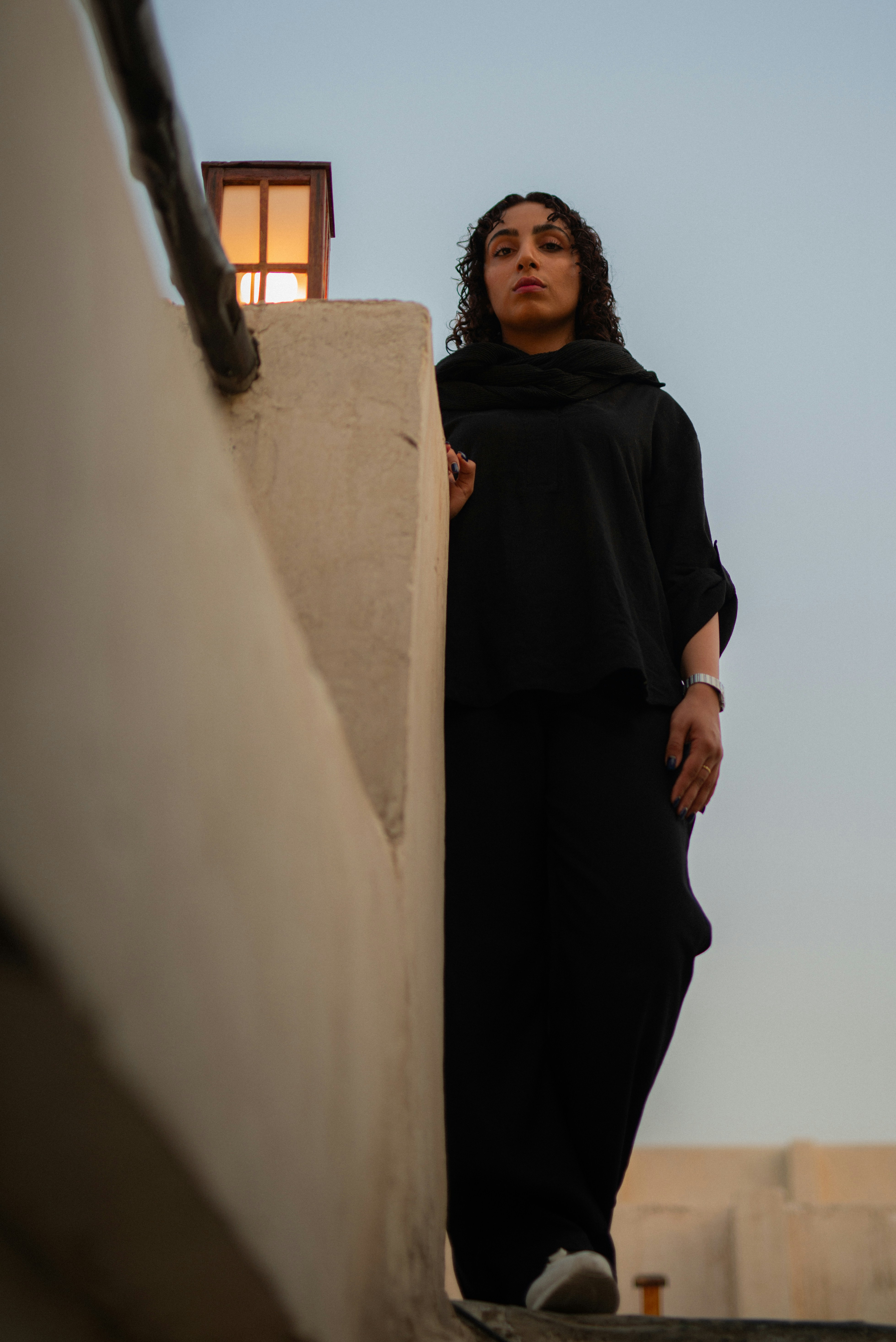 A woman standing on a ledge with her eyes closed photo – Free Bandar ...