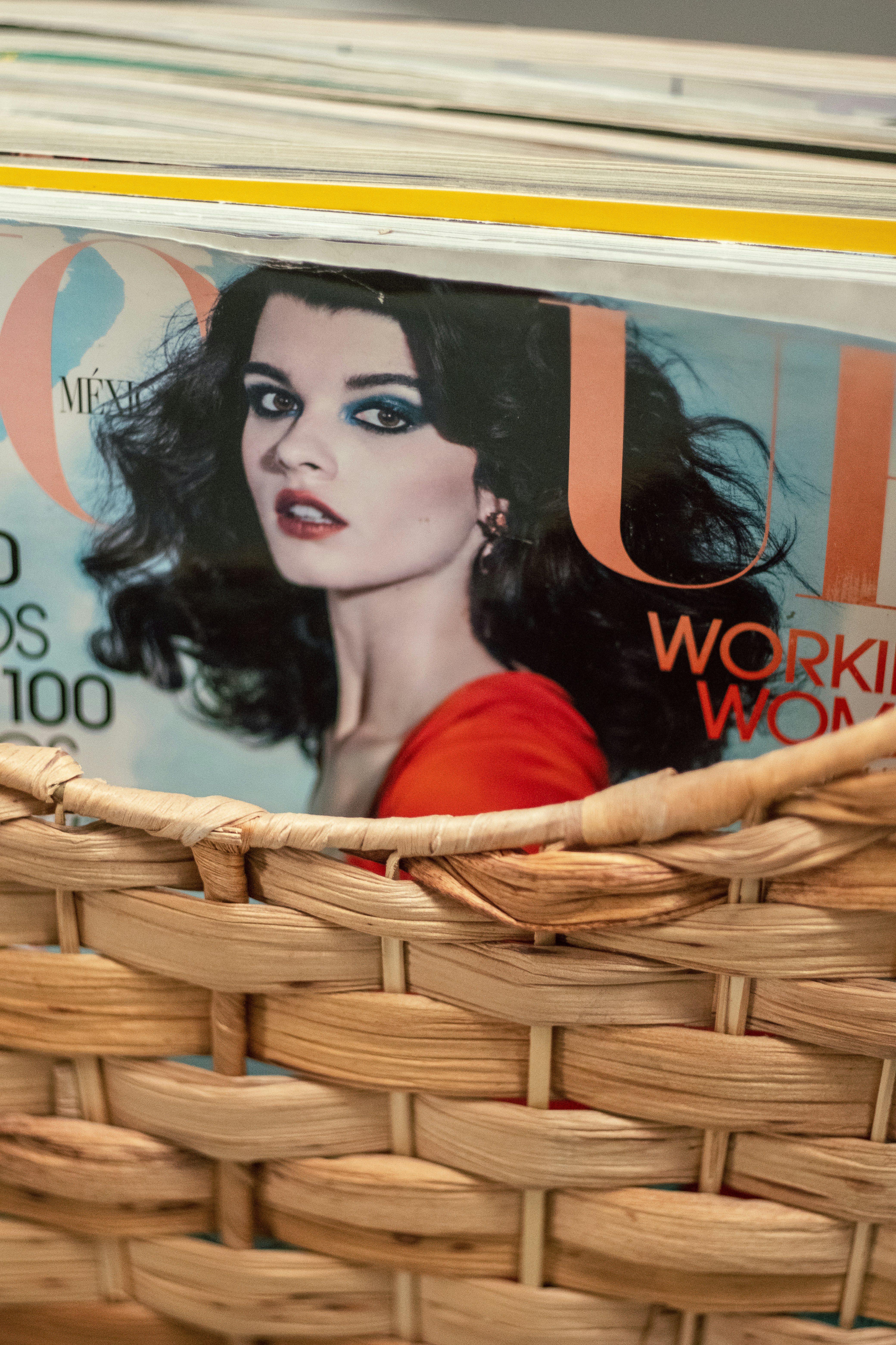 A magazine in a wicker basket on a shelf