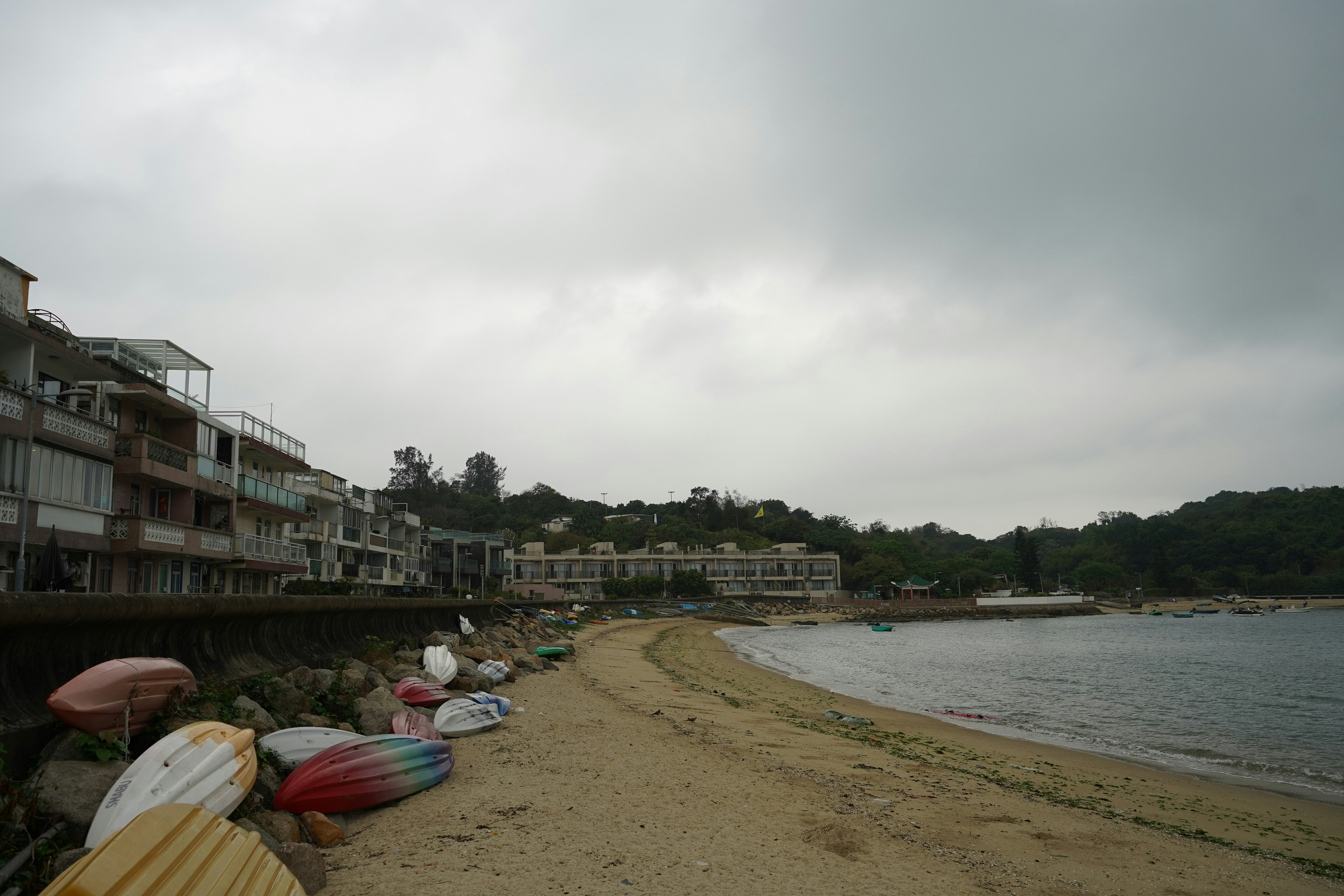 Muted Morning on the Beach: Colorful Boats Rest Against a Cloudy Horizon