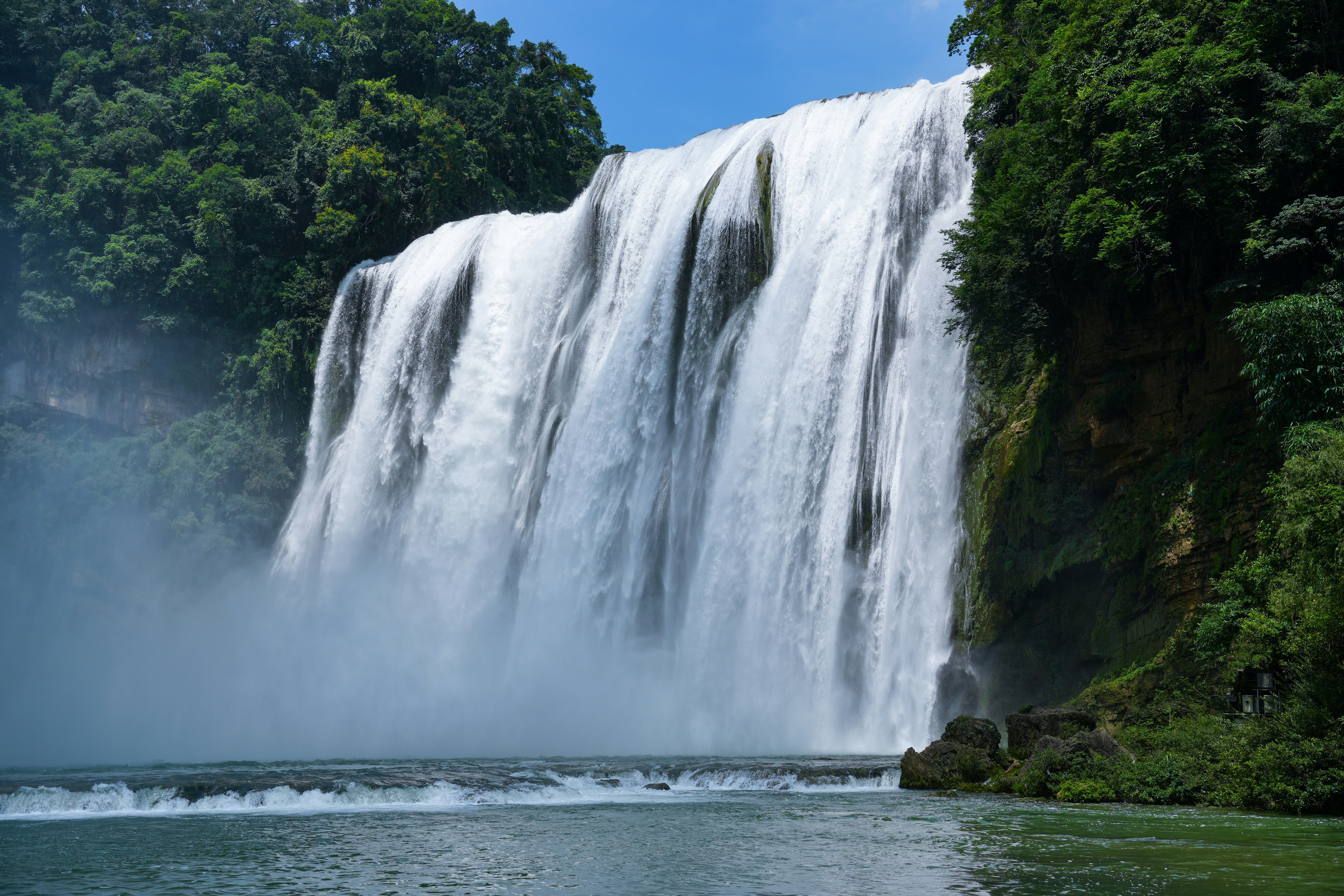 A large waterfall with water pouring out of it photo – Free Nature ...