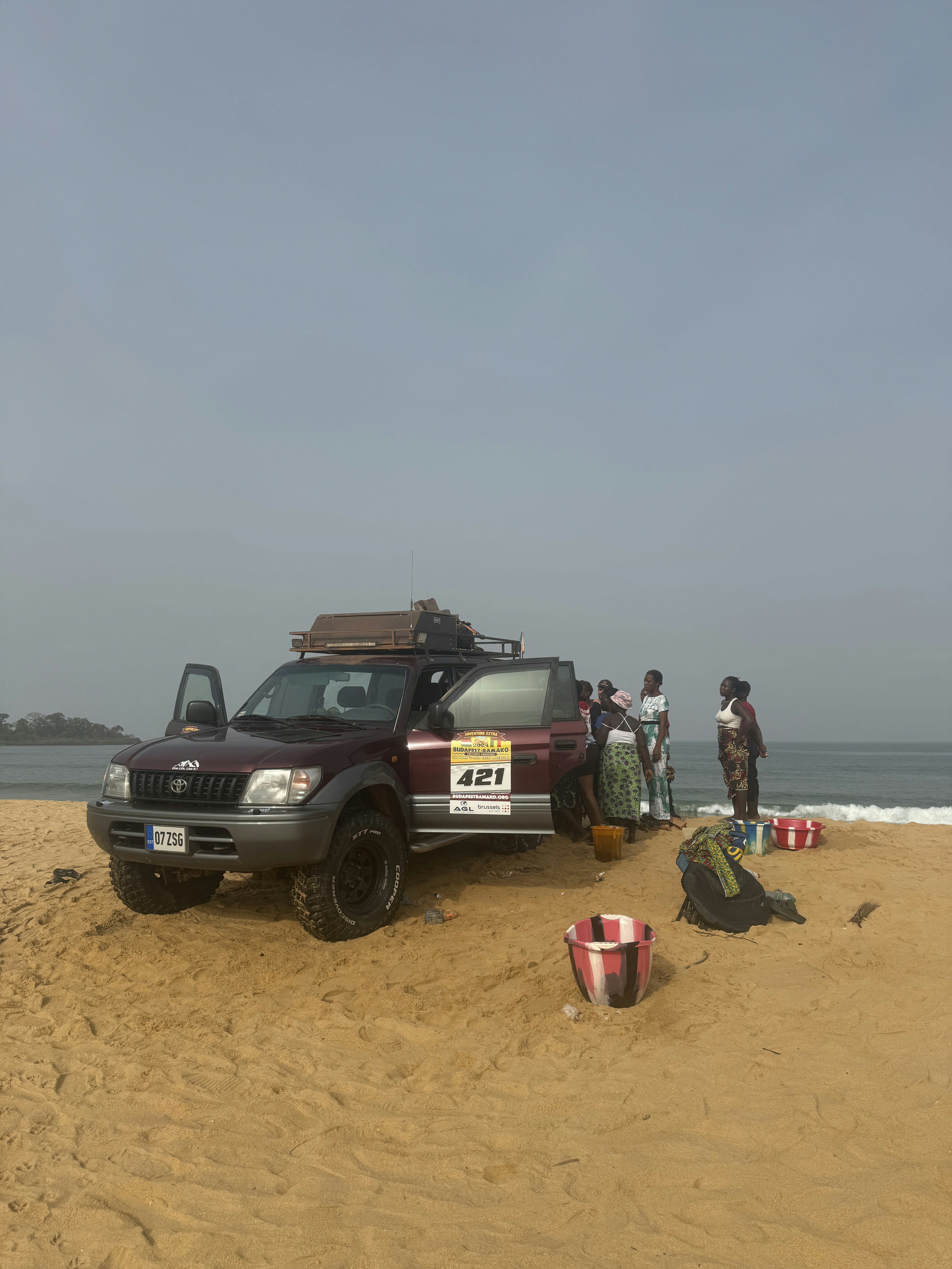Off‑Road Beach Rally: A Maroon SUV and Portable Crew on Sunlit Sand