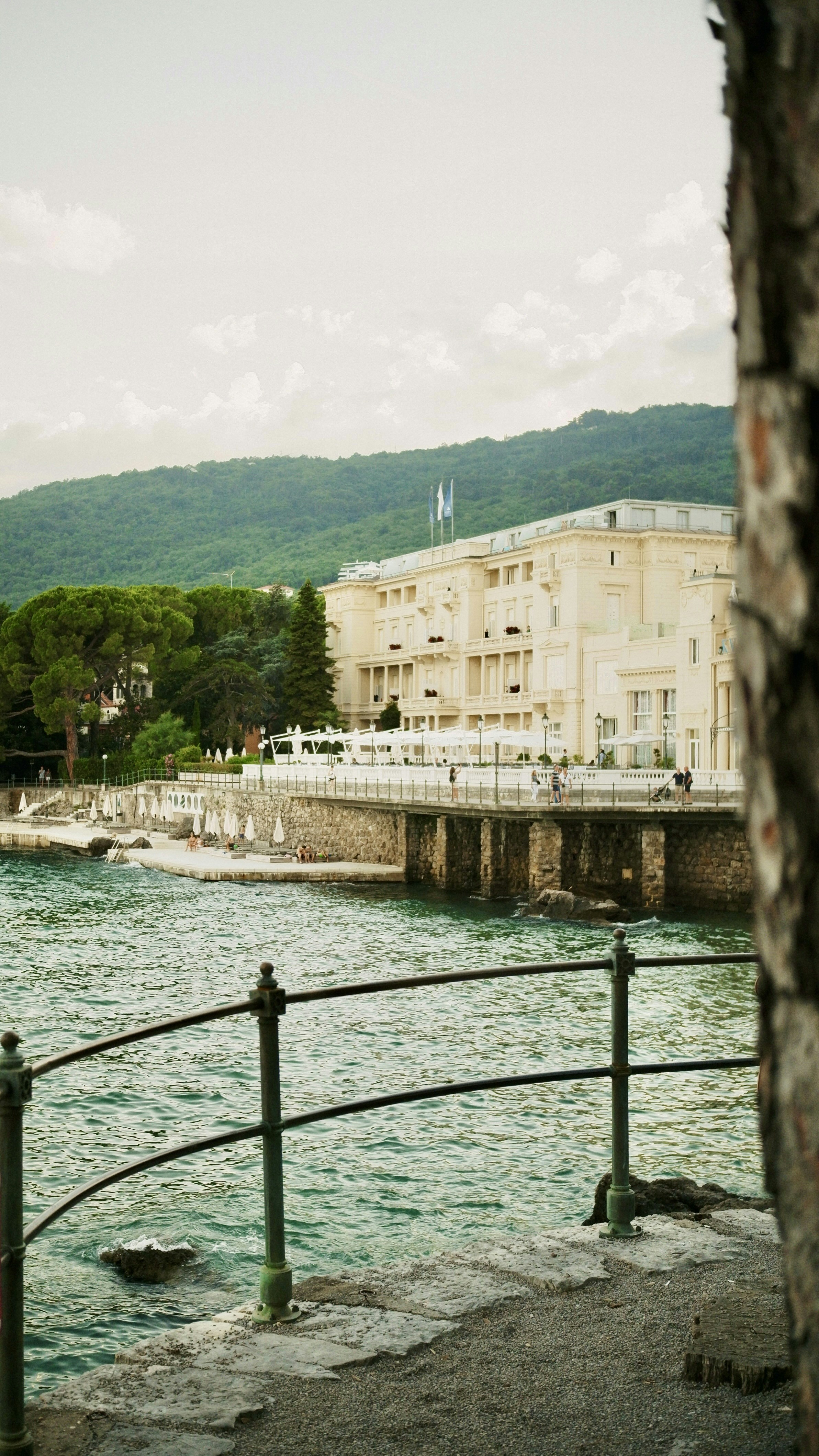 Quayside Grandeur: Beige Facade Framed by Rail and Sea