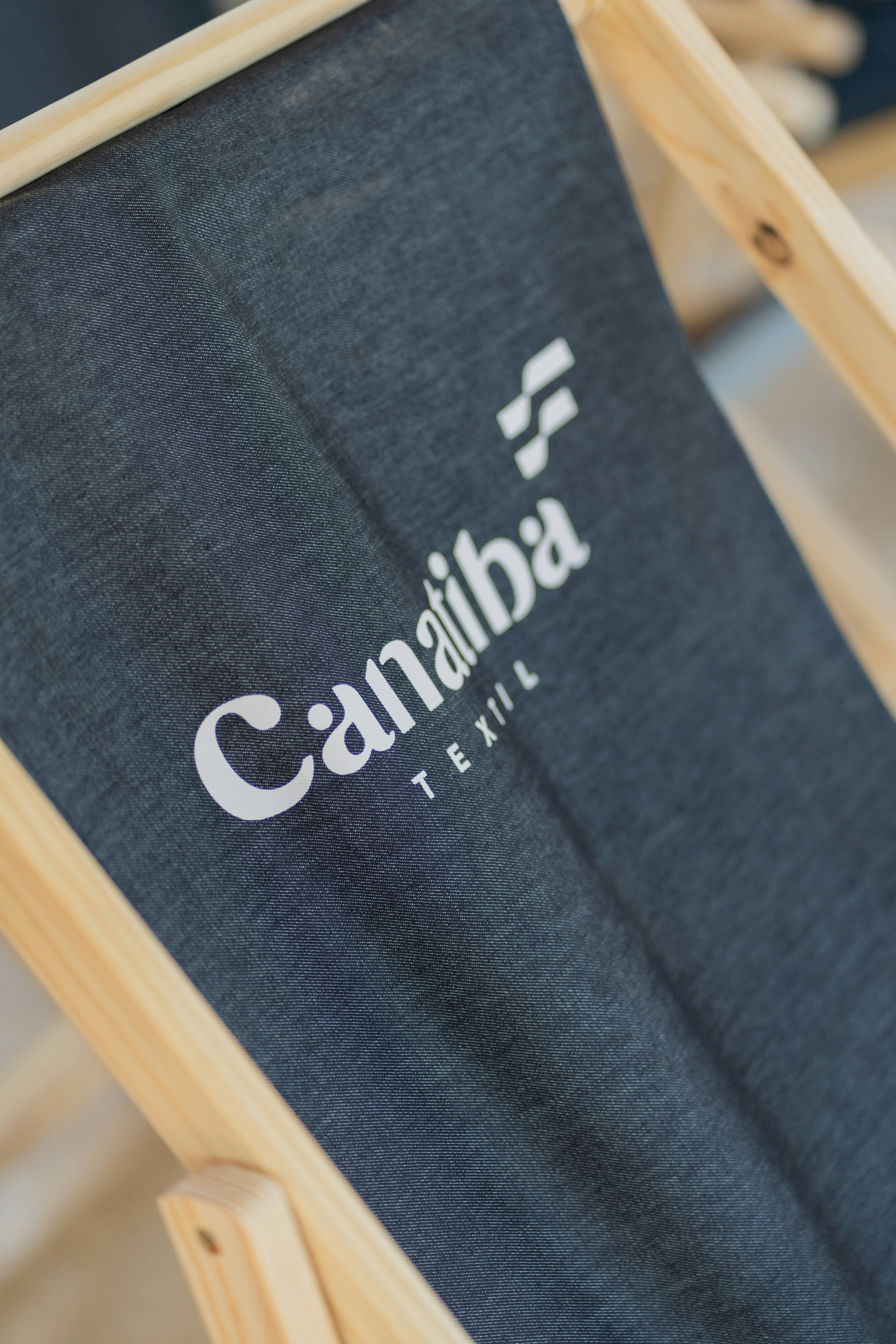 Close-Up Indigo Textile with White Brand Logo in a Light Wood Frame