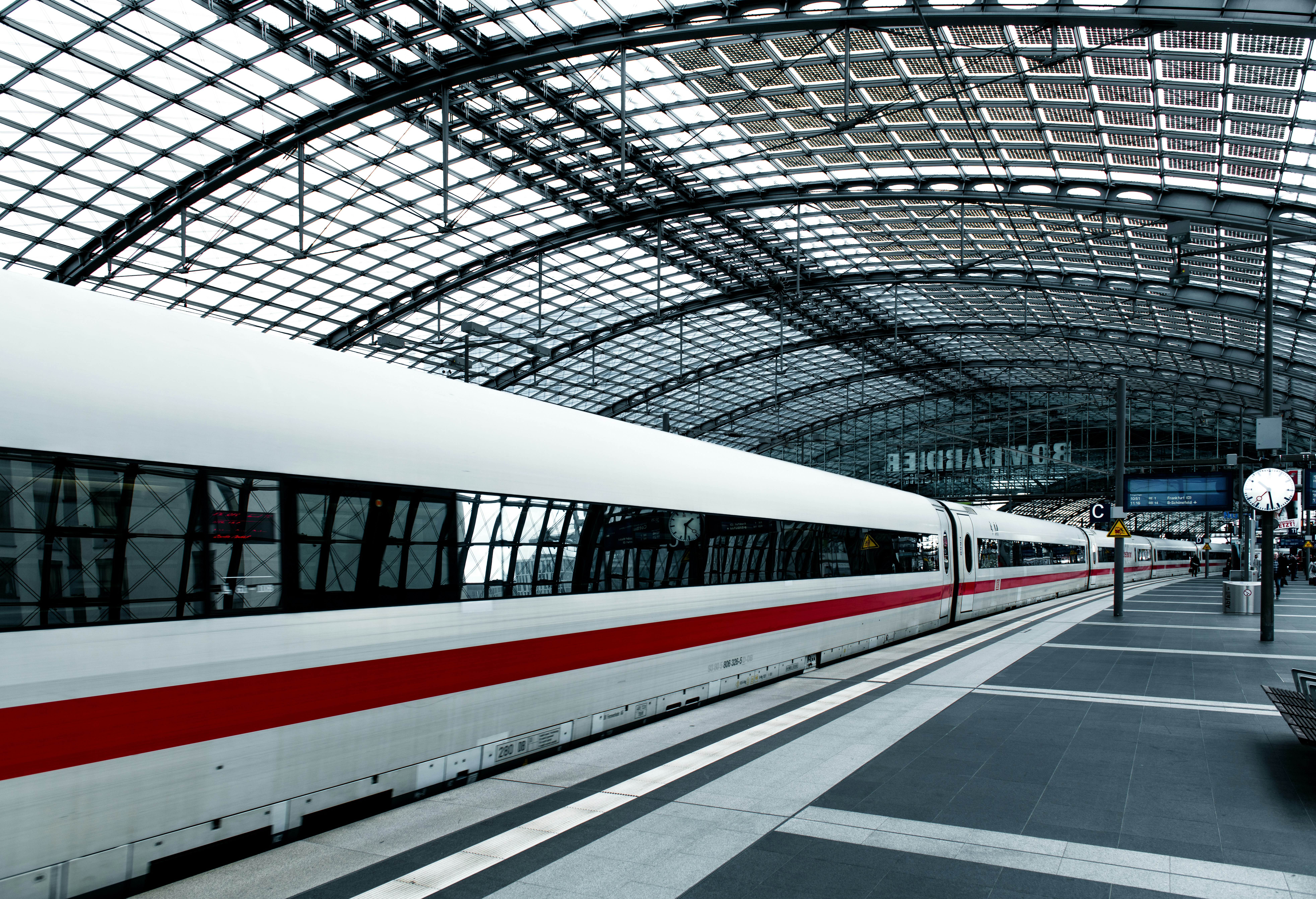 A white and red train traveling through a train station photo – Free ...