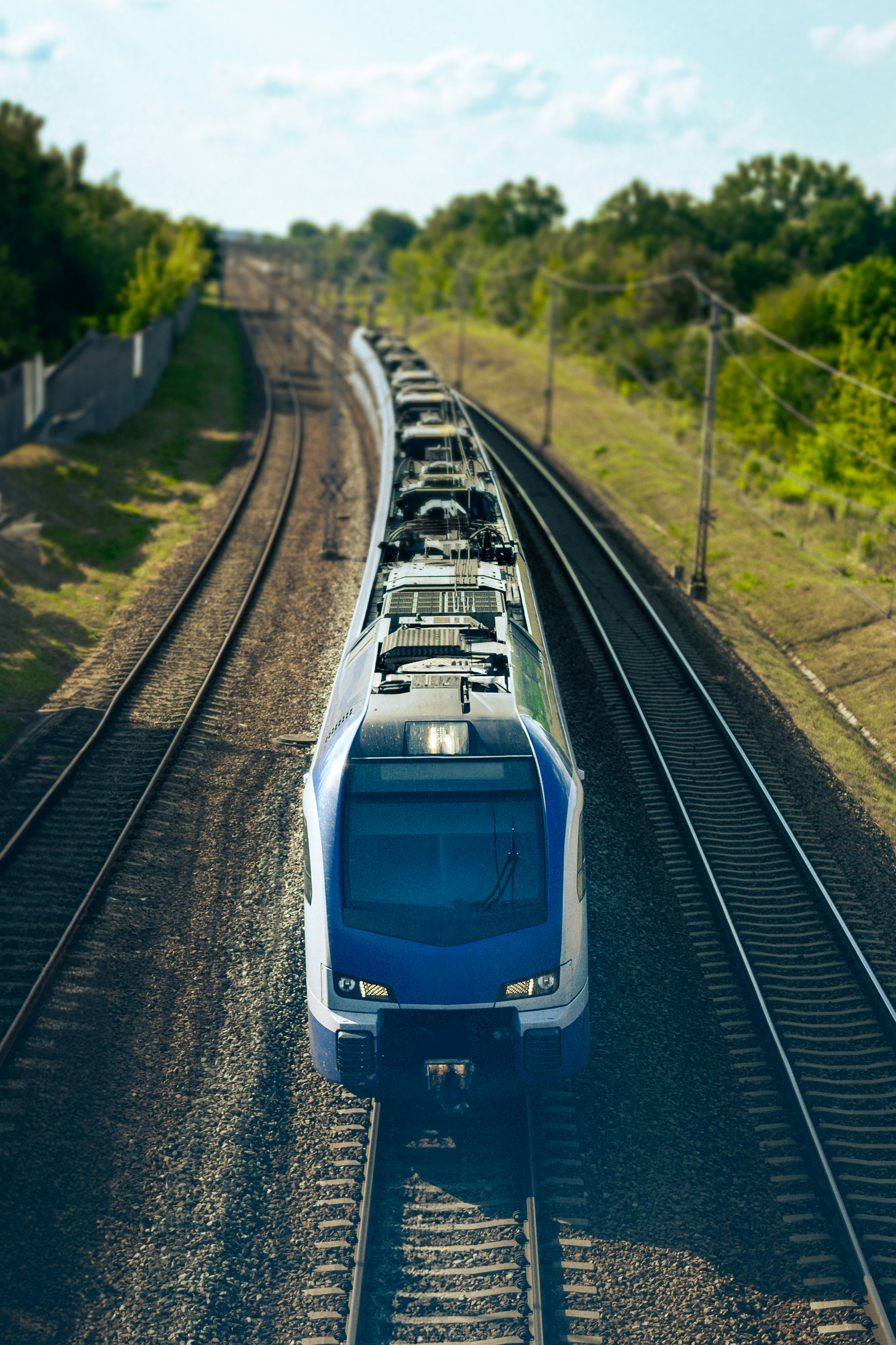 A blue and white train traveling down train tracks photo – Free Train ...