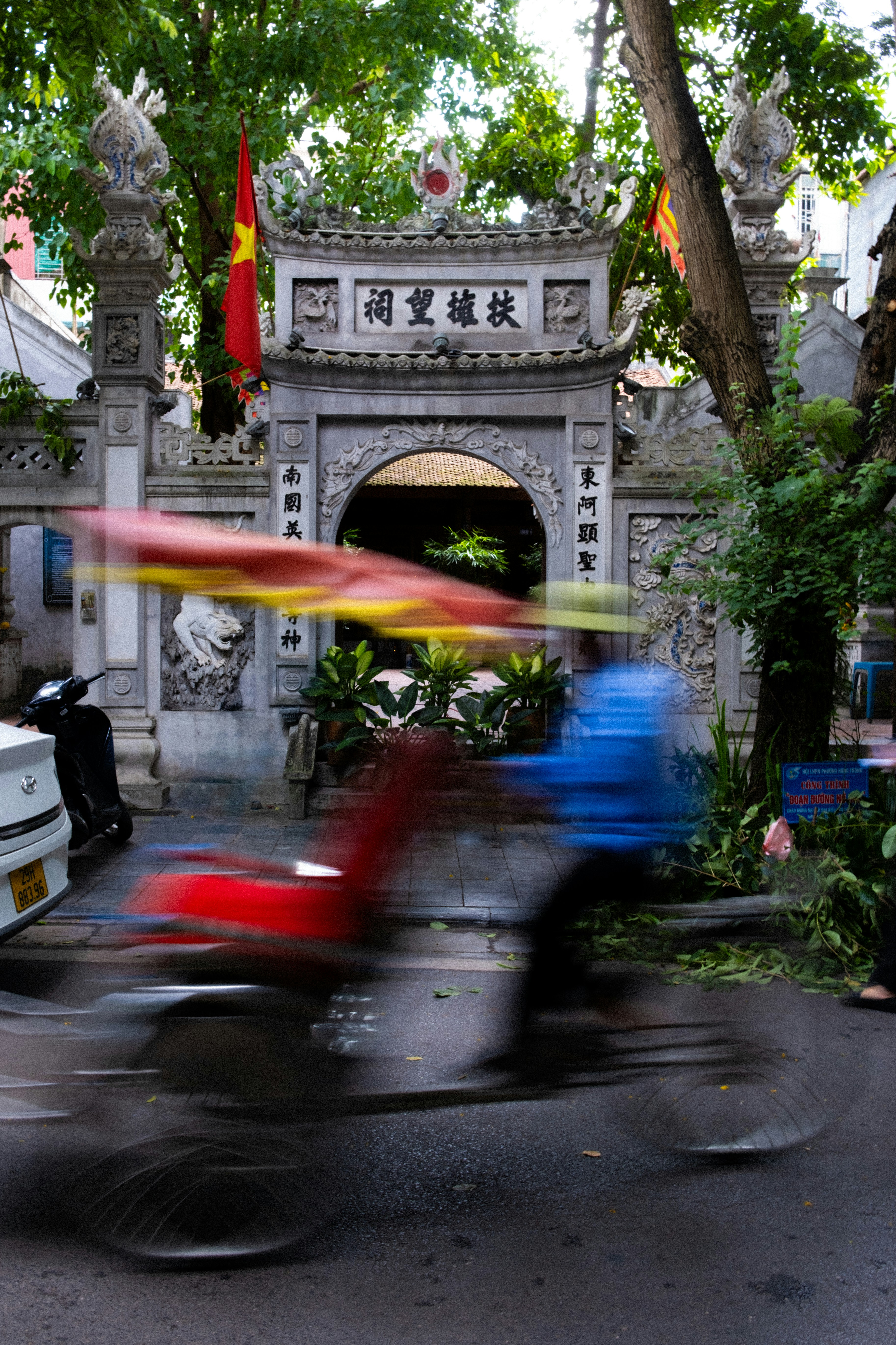 A Rikshaw passing buy with a Buddhist temple in the background, taken in long exposure.