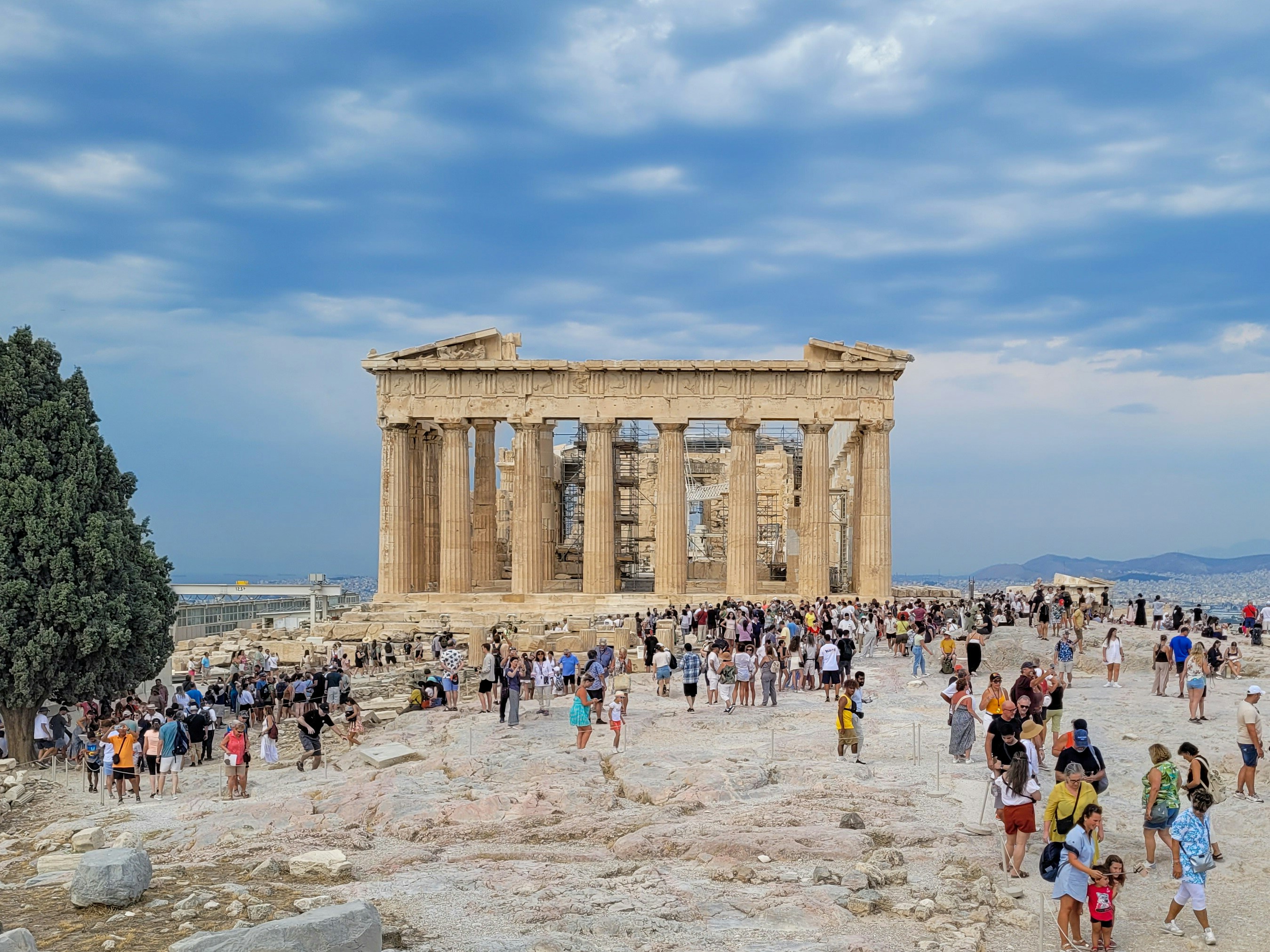 A crowd of people walking around a stone building photo – Free ...