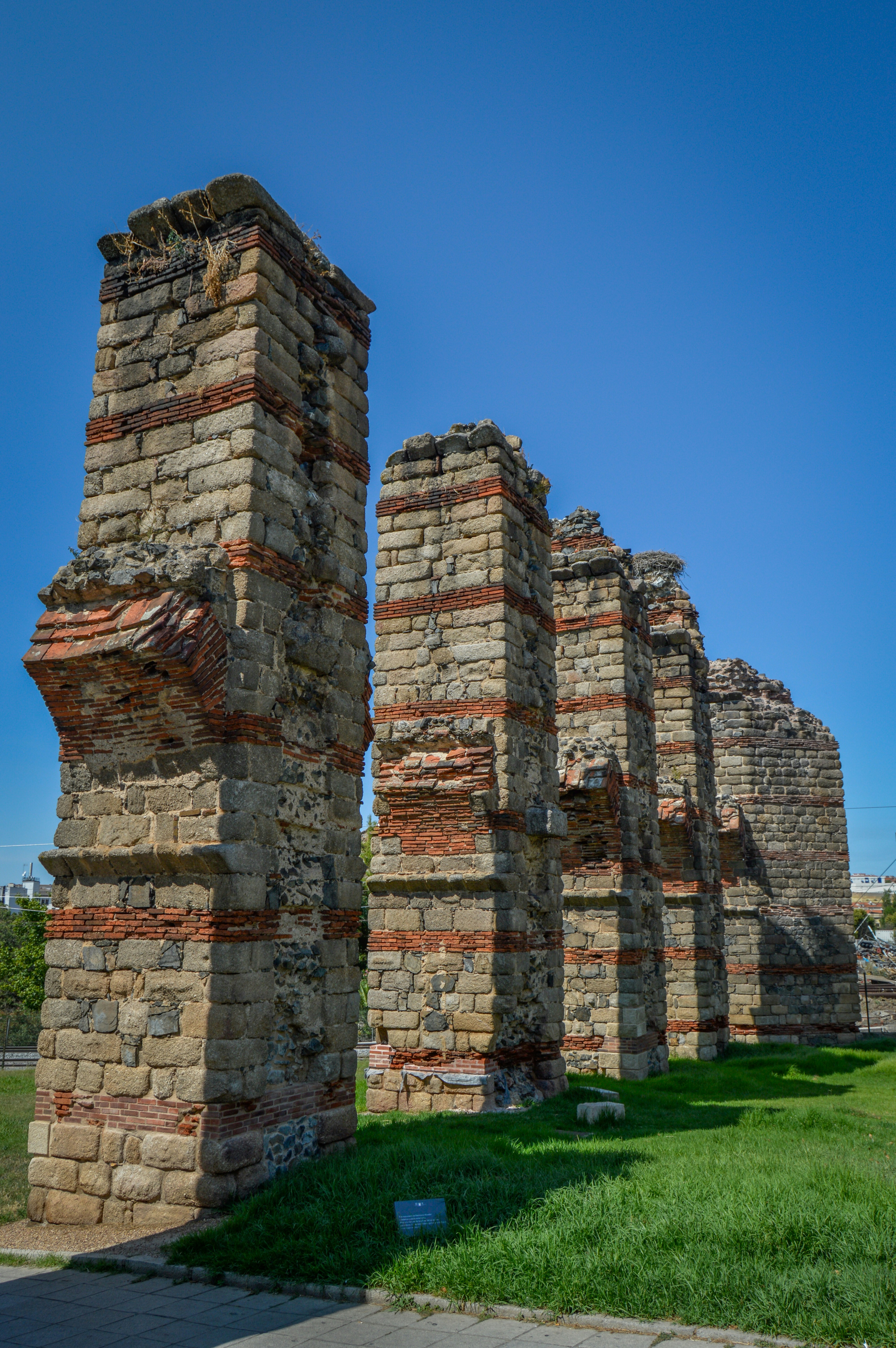 Sunlit Row of Ancient Stone Arches Against a Cerulean Sky