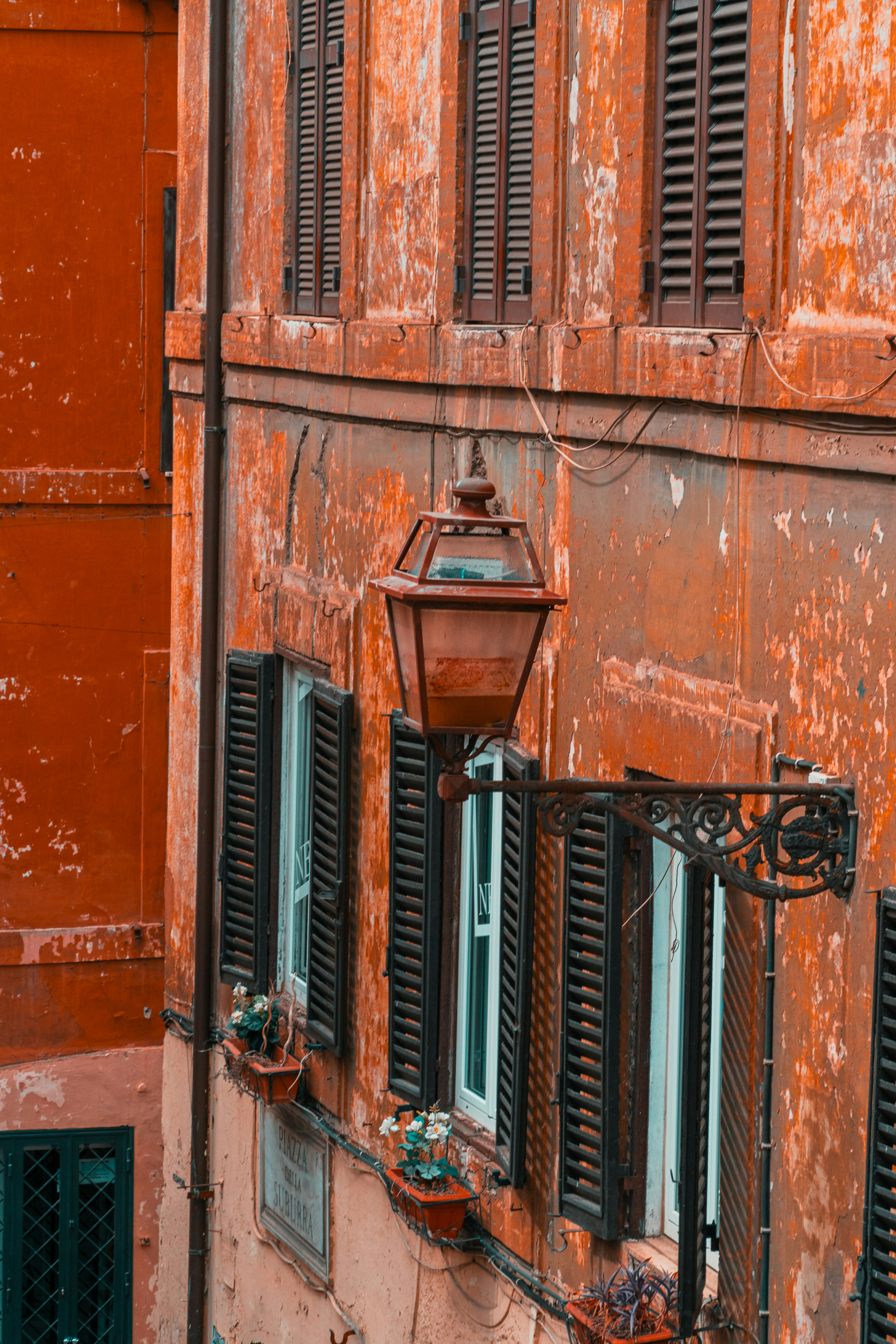 Old Street Lantern Framed by Weathered Orange Facade