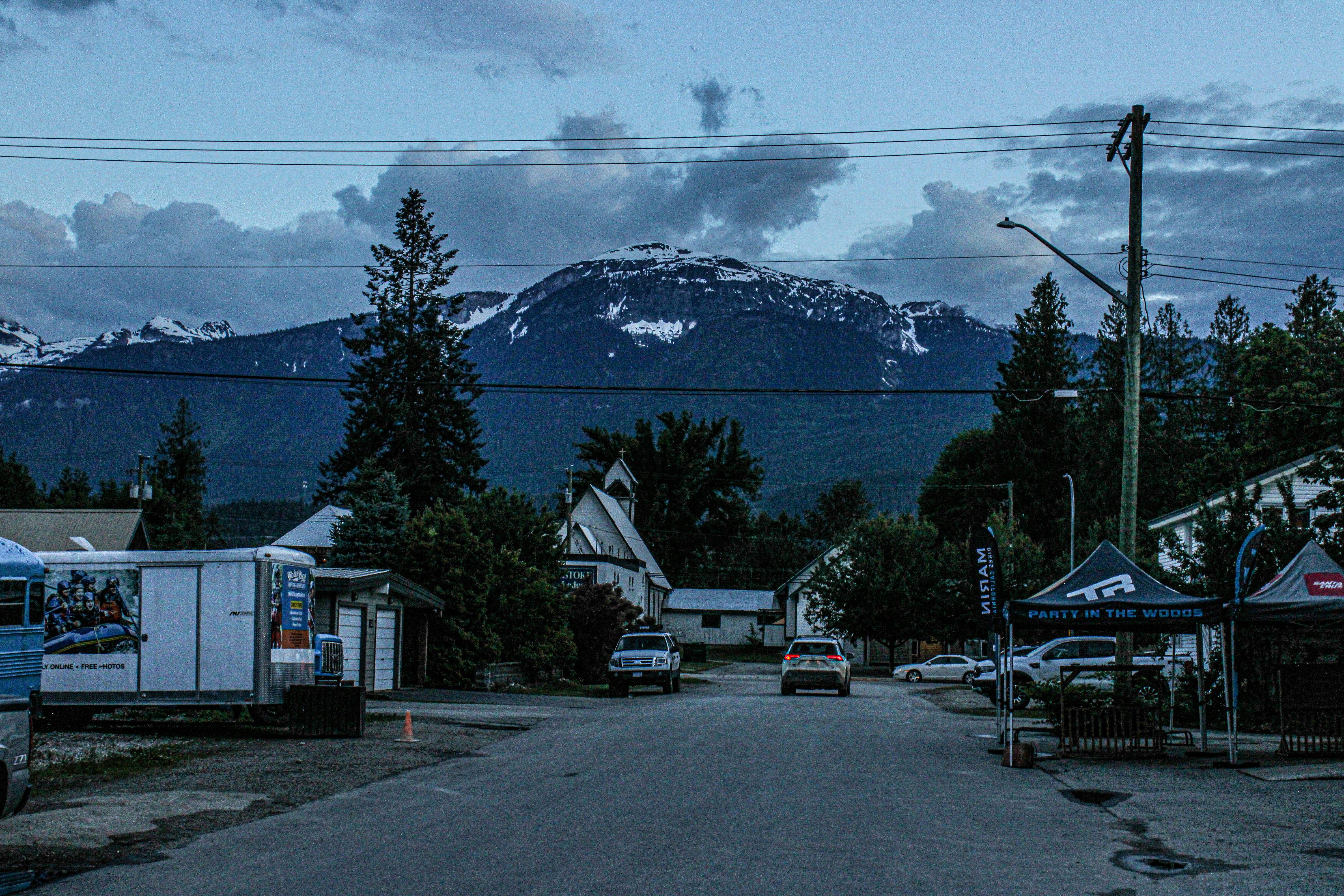 Dusk Along a Mountain Village Street with Snow-Capped Backdrop