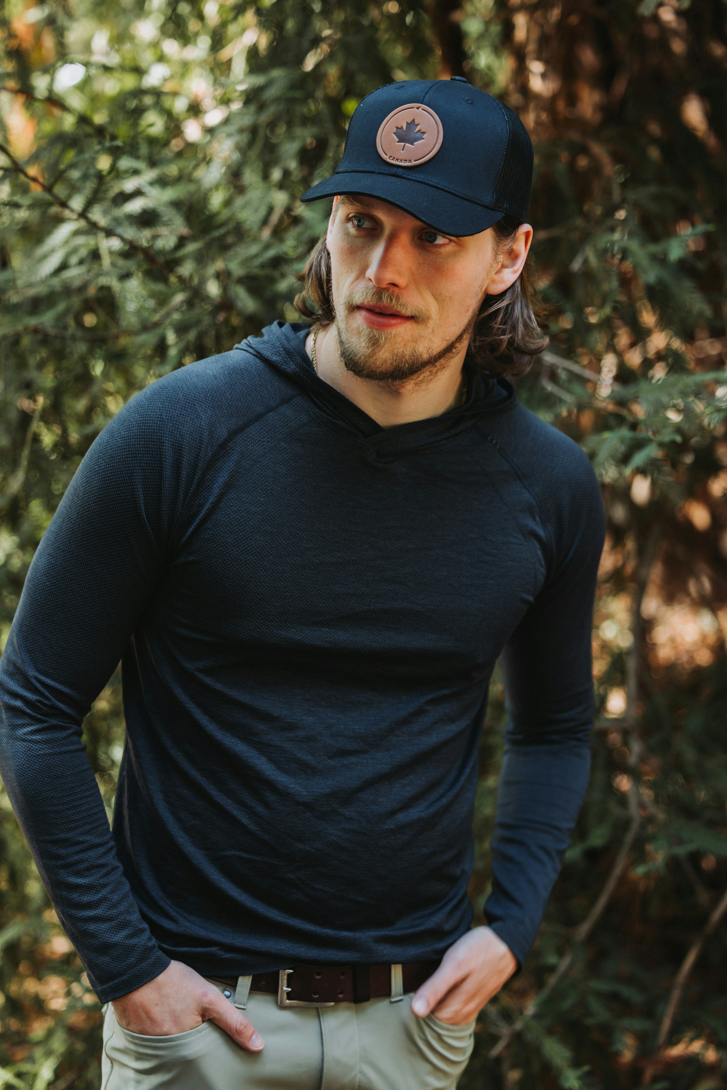 Photography by Ryan Hartford / Ecliptic Media Photography. Man wearing our heat-pressed leather patch hat in the forest. He is wearing our Maple Leaf hat from our Canada Collection. Leather patch hat from Byward Outfitters www.bywardoutfitters.com
