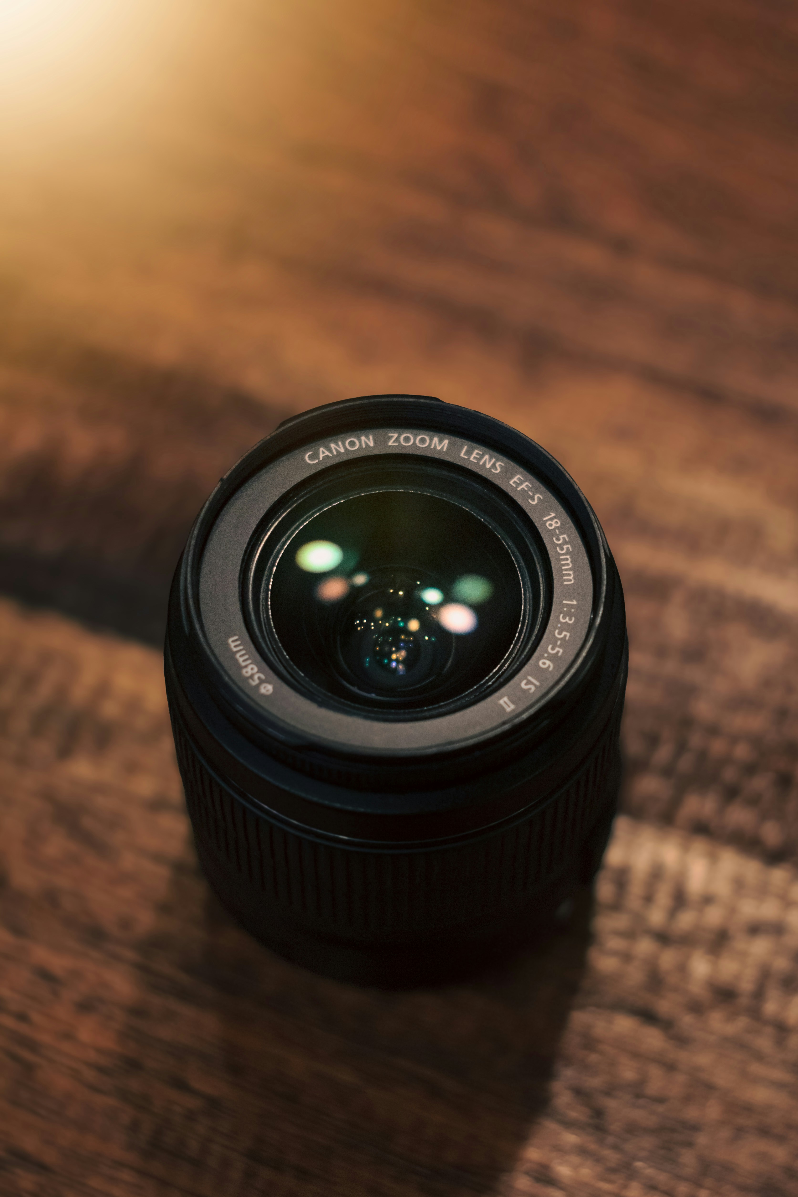A camera lens sitting on top of a wooden table photo – Free Camera lens ...