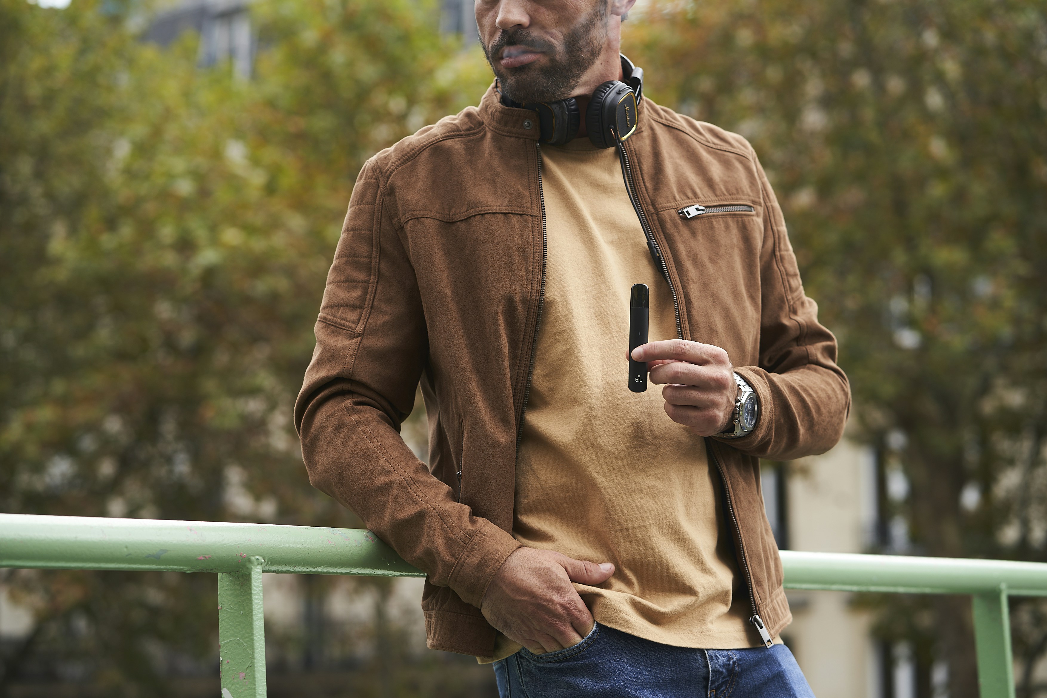 Autumn Street Portrait: Slim Vape Clutched by a Man in a Brown Suede Jacket