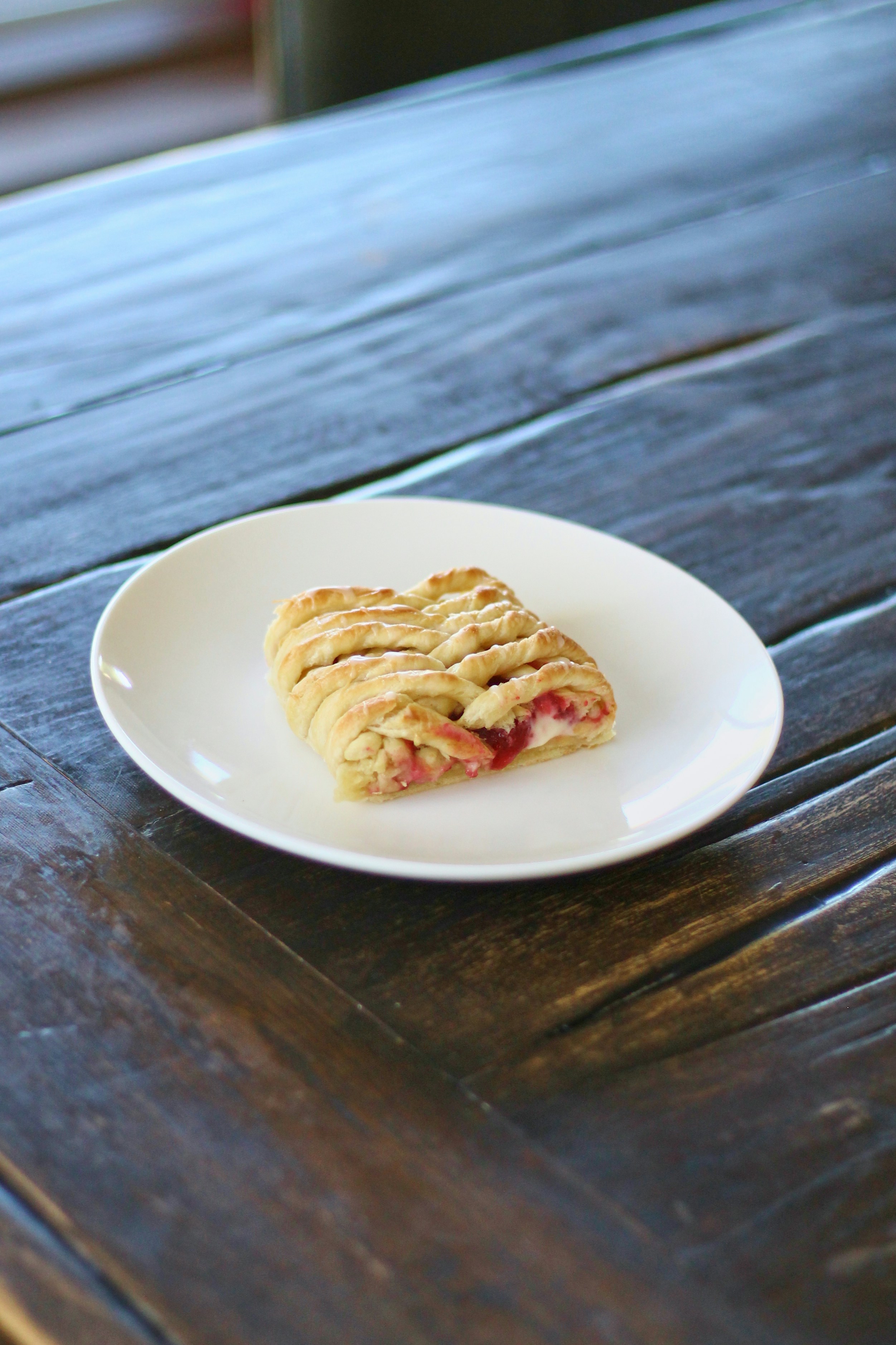 A piece of pie on a white plate on a wooden table