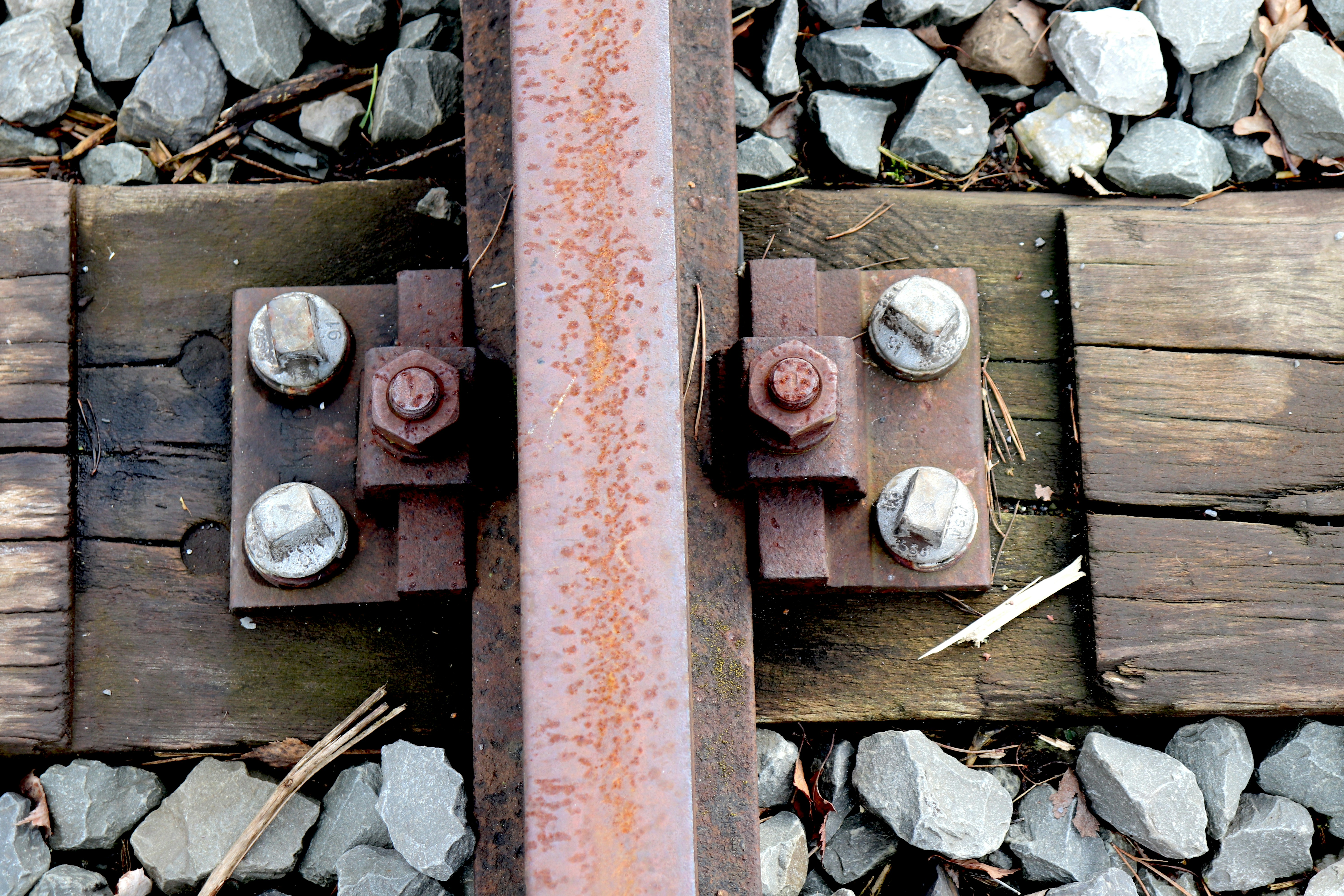 Iron Grip on Weathered Rails: a rusted joint under ballast