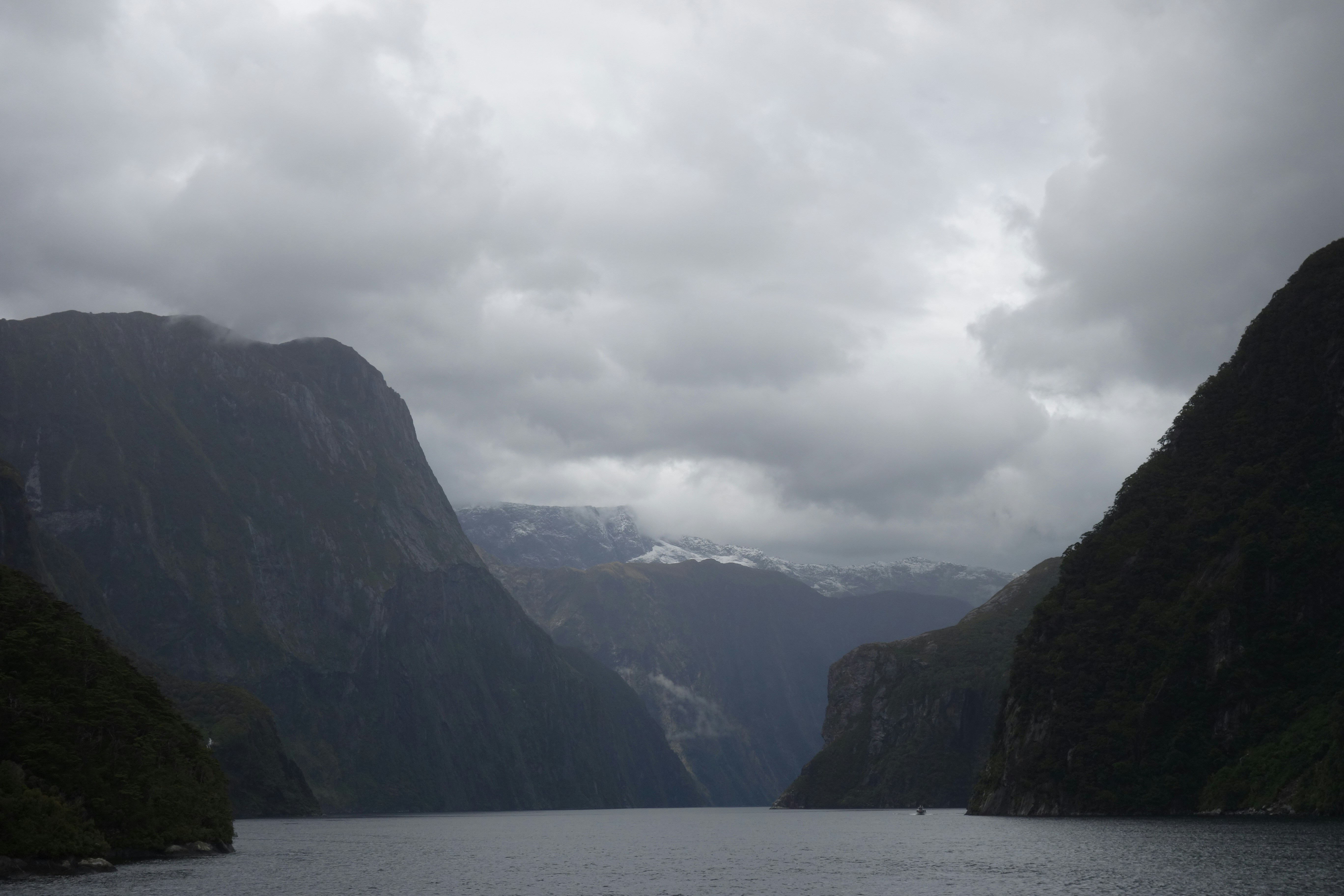 A body of water surrounded by mountains under a cloudy sky photo – Free New zealand Image on ...