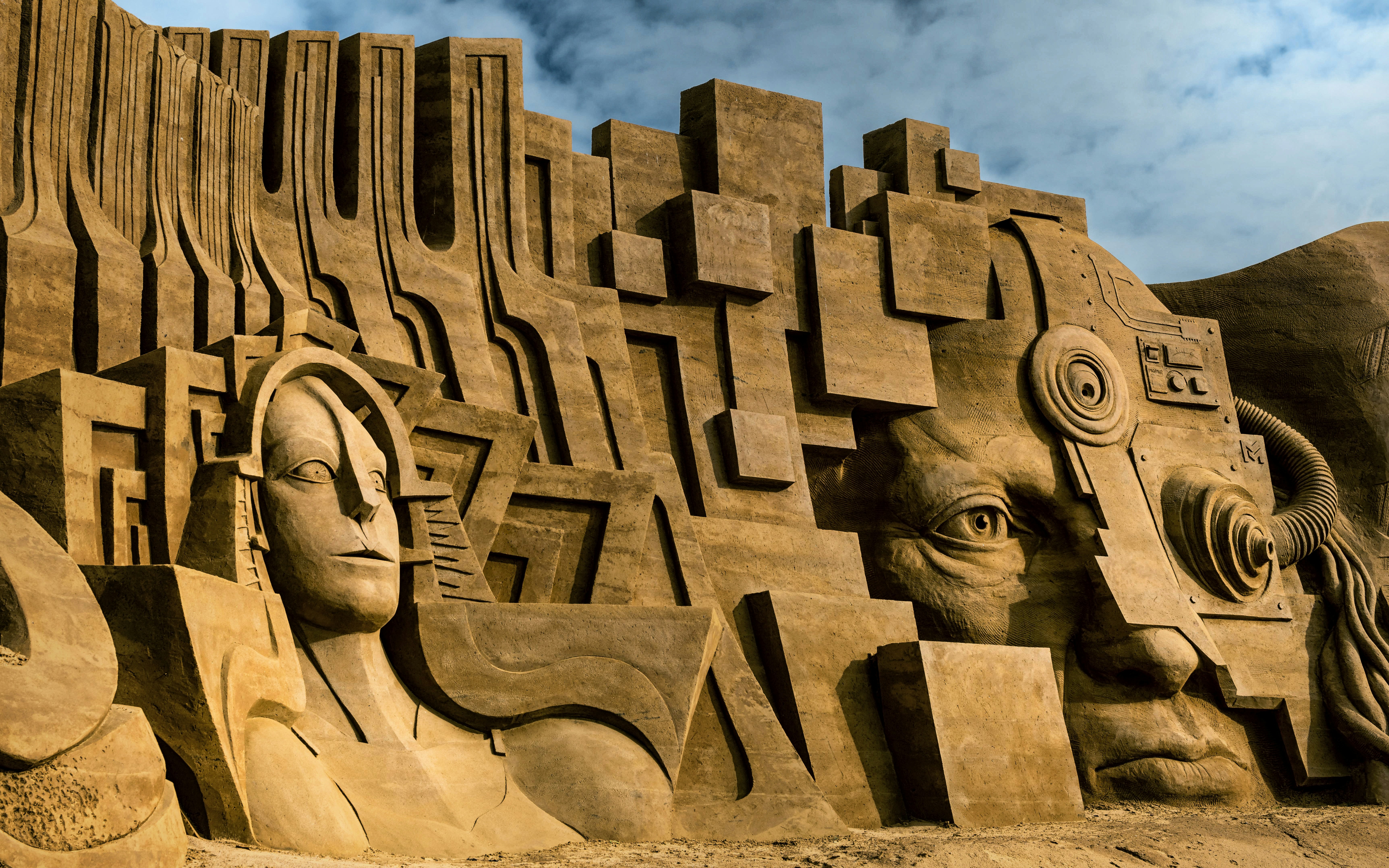 A sand sculpture of a group of heads photo – Free Dänemark Image on ...