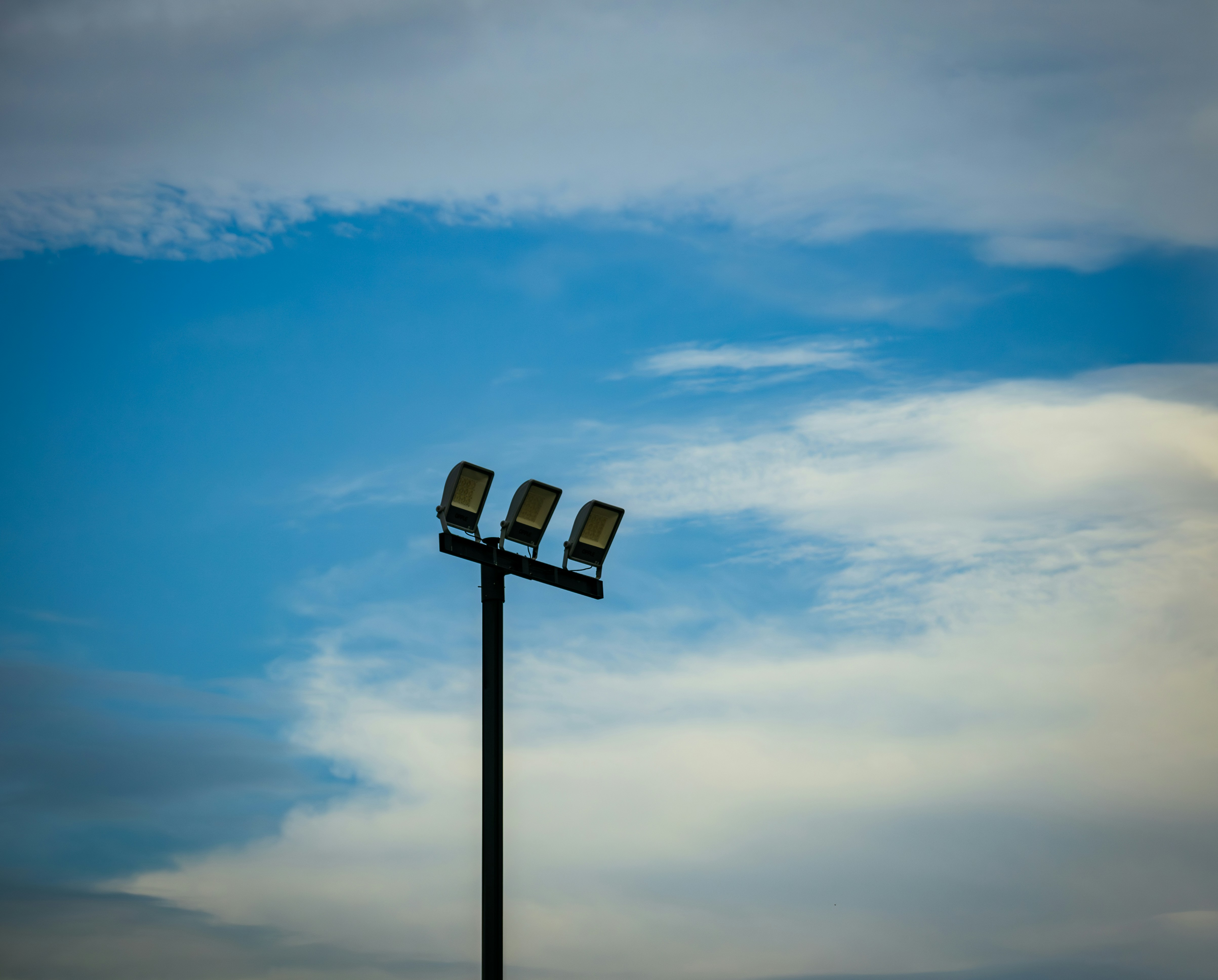Four-Lamp Sentinel Under a Quiet Blue Sky