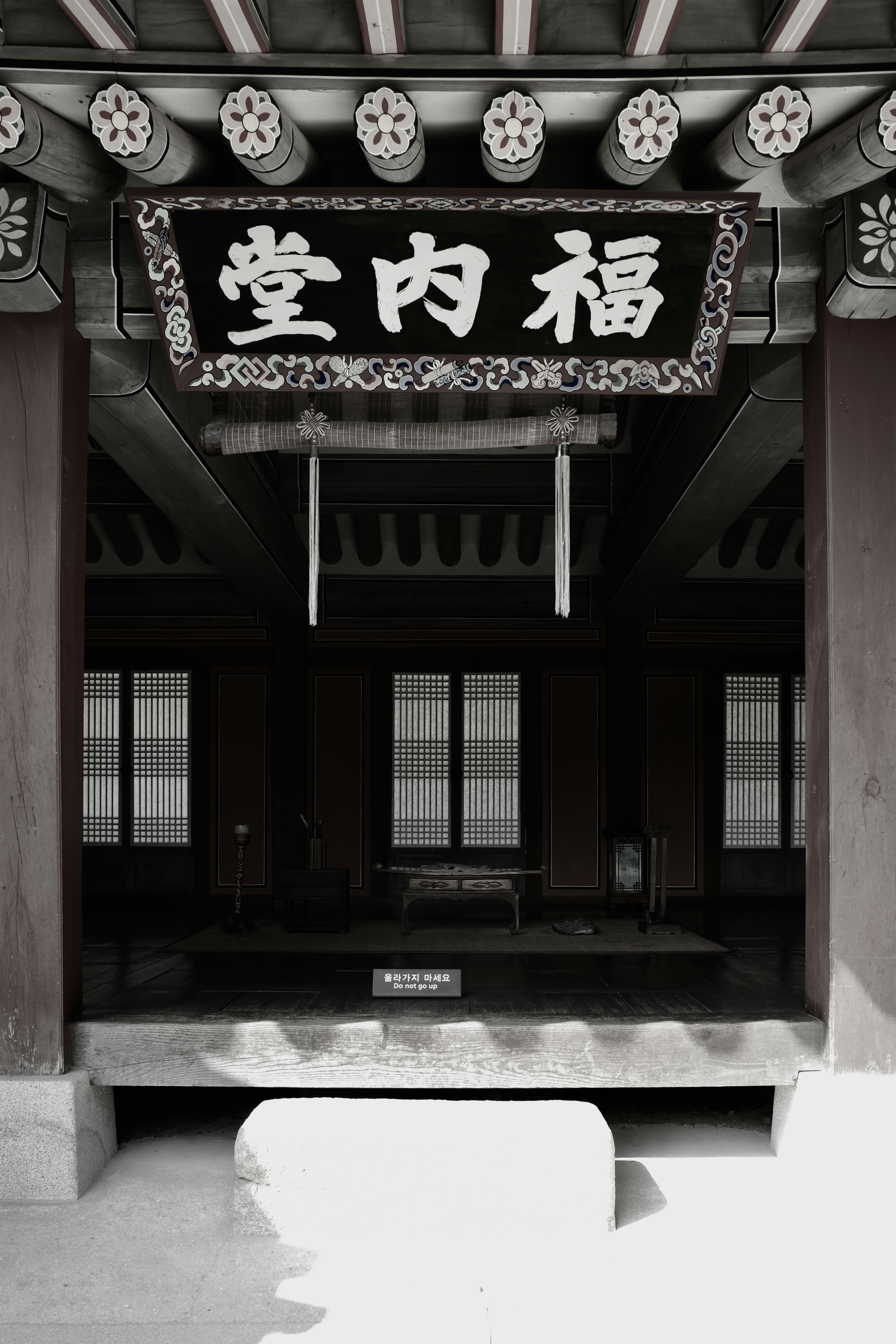 Monochrome Temple Threshold: Signboard Framing a Quiet Interior