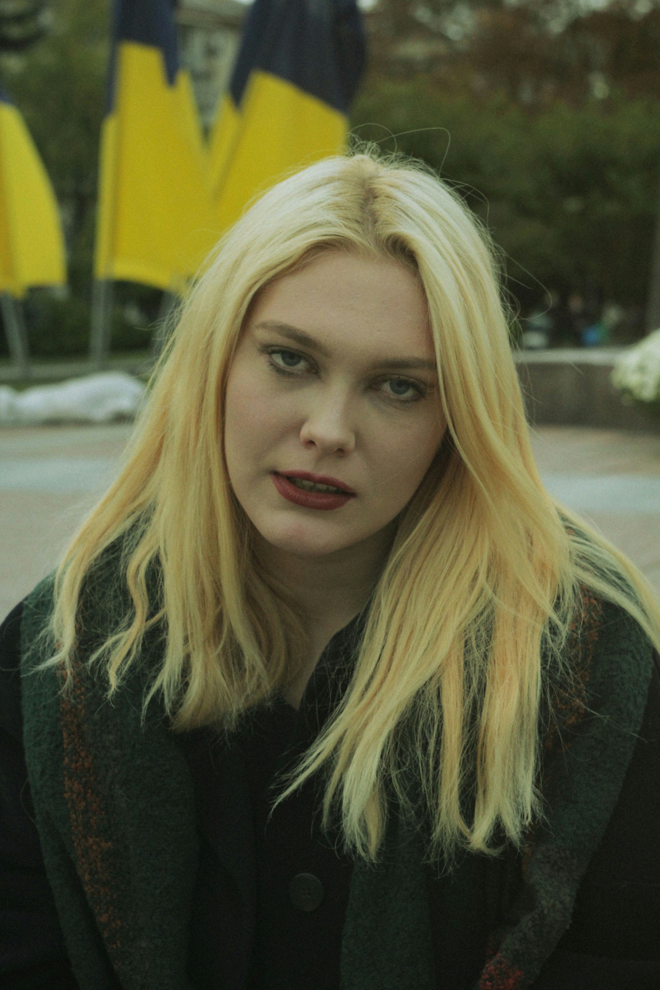 Portrait Beneath Amber Canopies: The Quiet Gaze of a Blonde in the Park