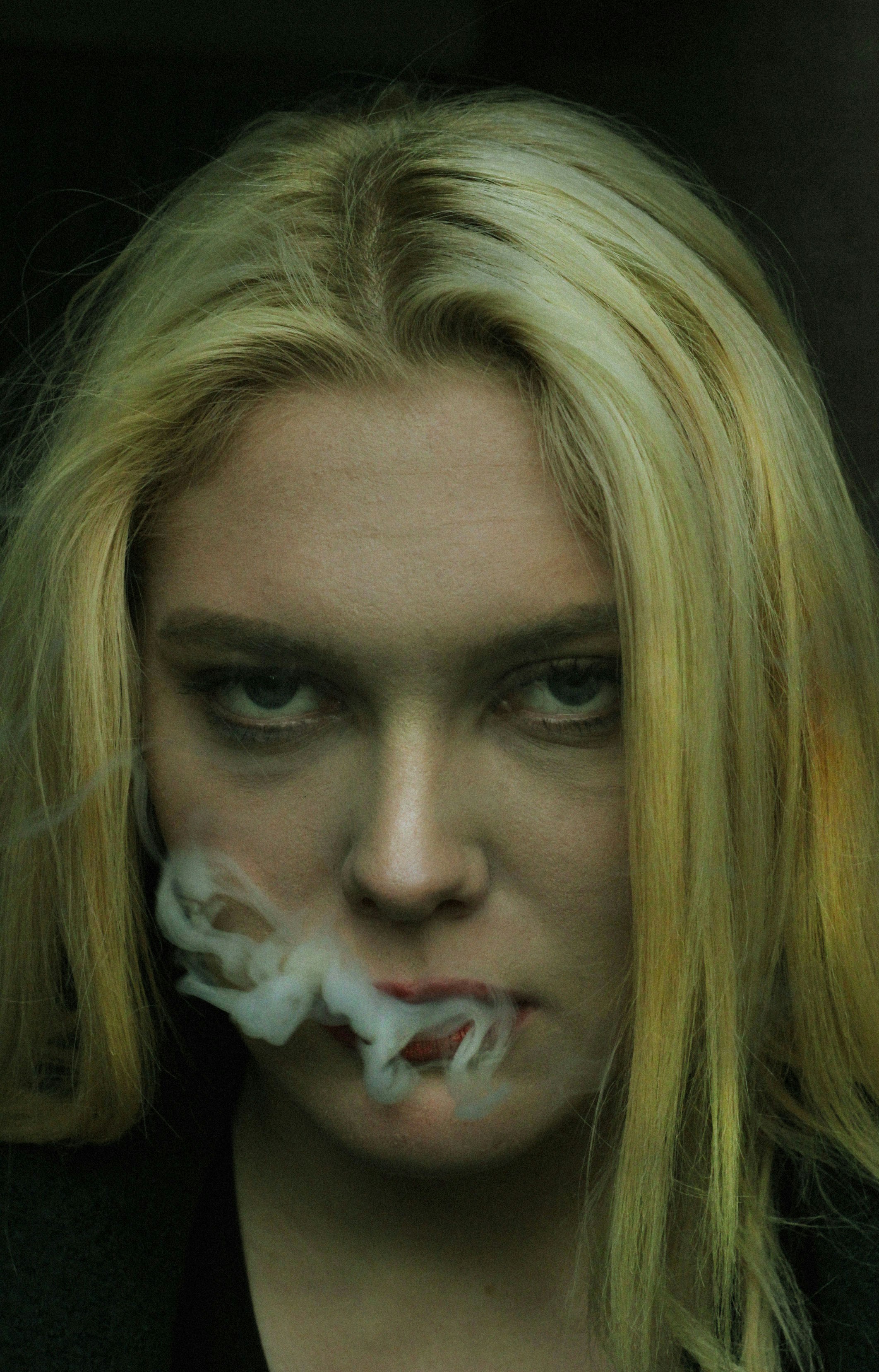 A woman with white smoke coming out of her mouth