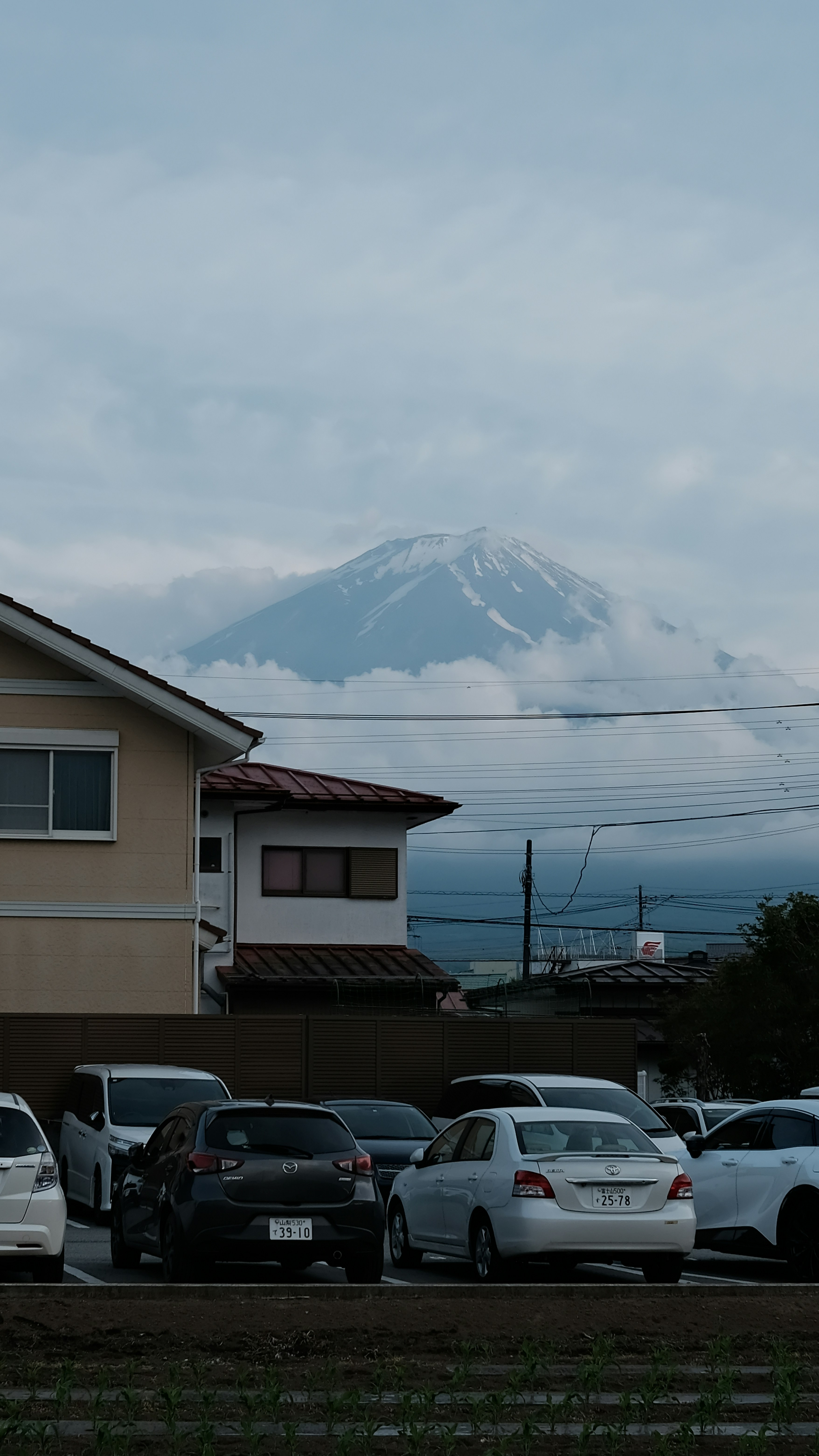 Mount Fuji | A group of cars parked in front of a house