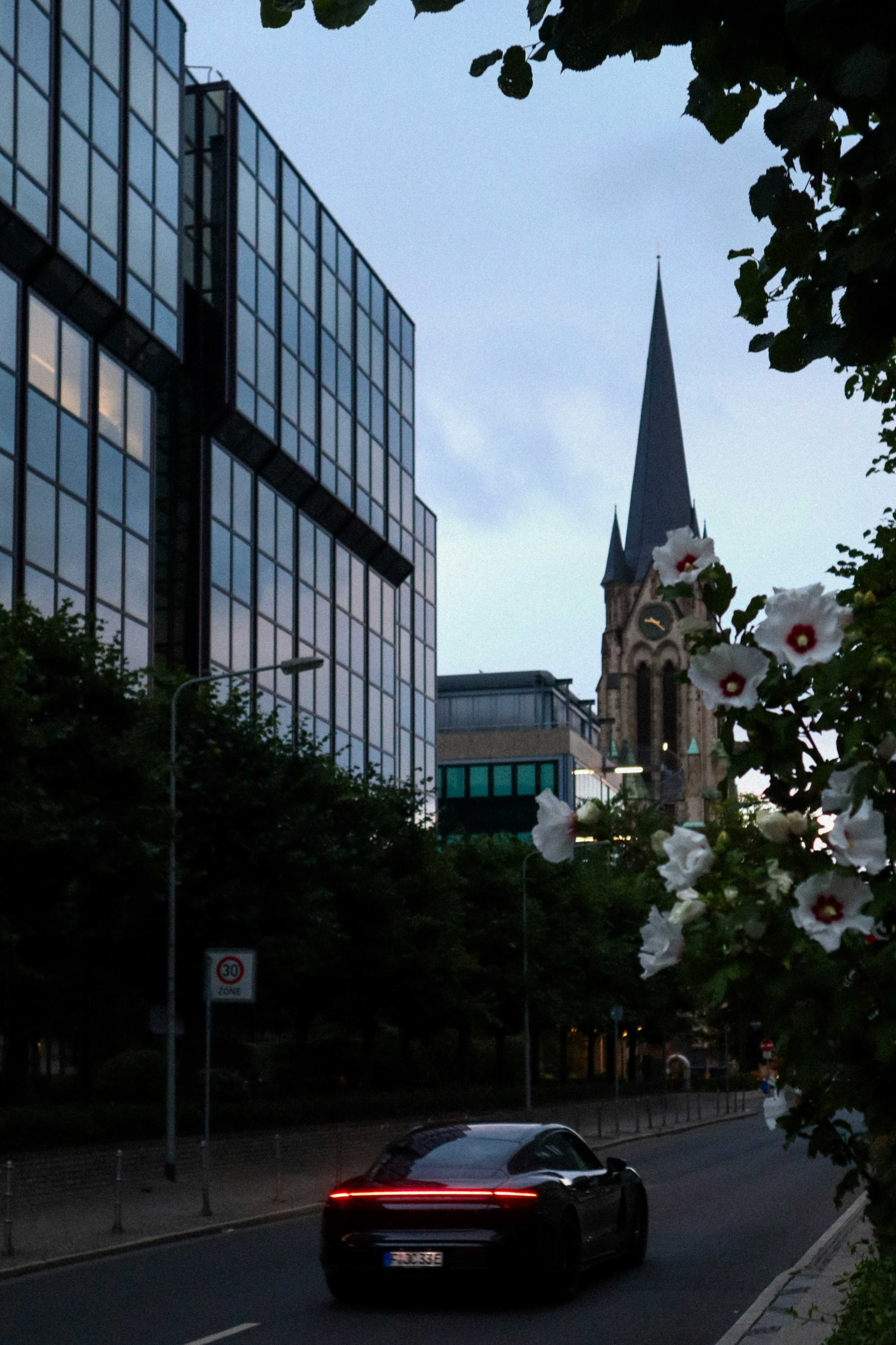 Taillight Echo Between Glass and Spire