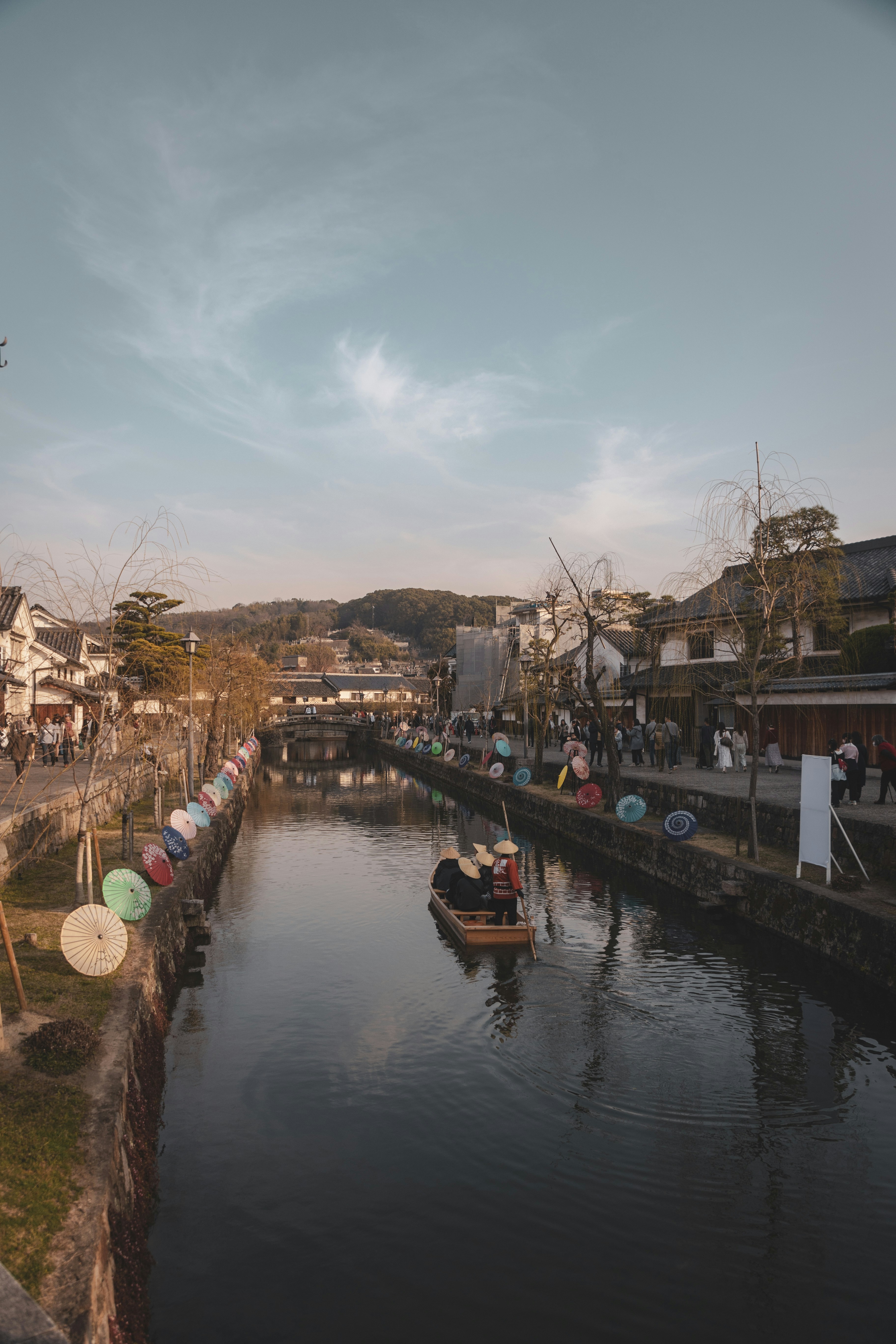 Twilight Canal: A Quiet Boat Threading Through a Corridor of Colorful Umbrellas