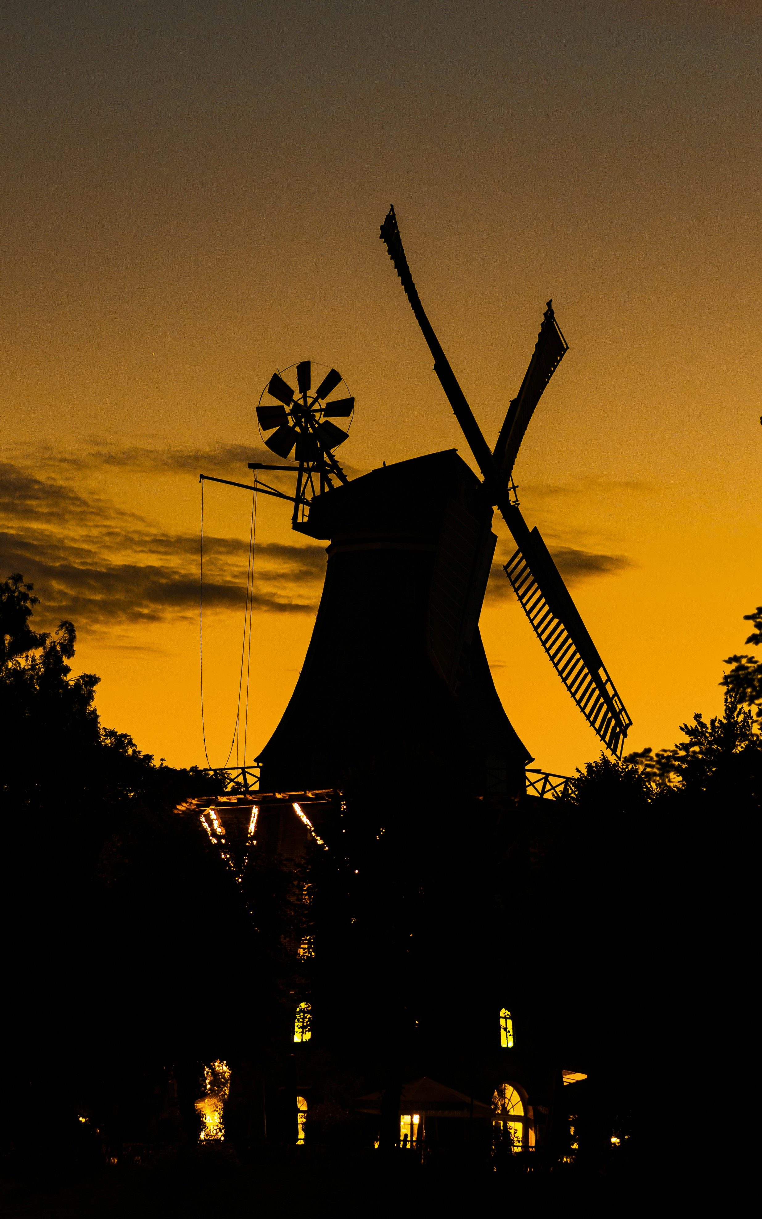 A windmill is silhouetted against the evening sky photo – Free Bremen ...
