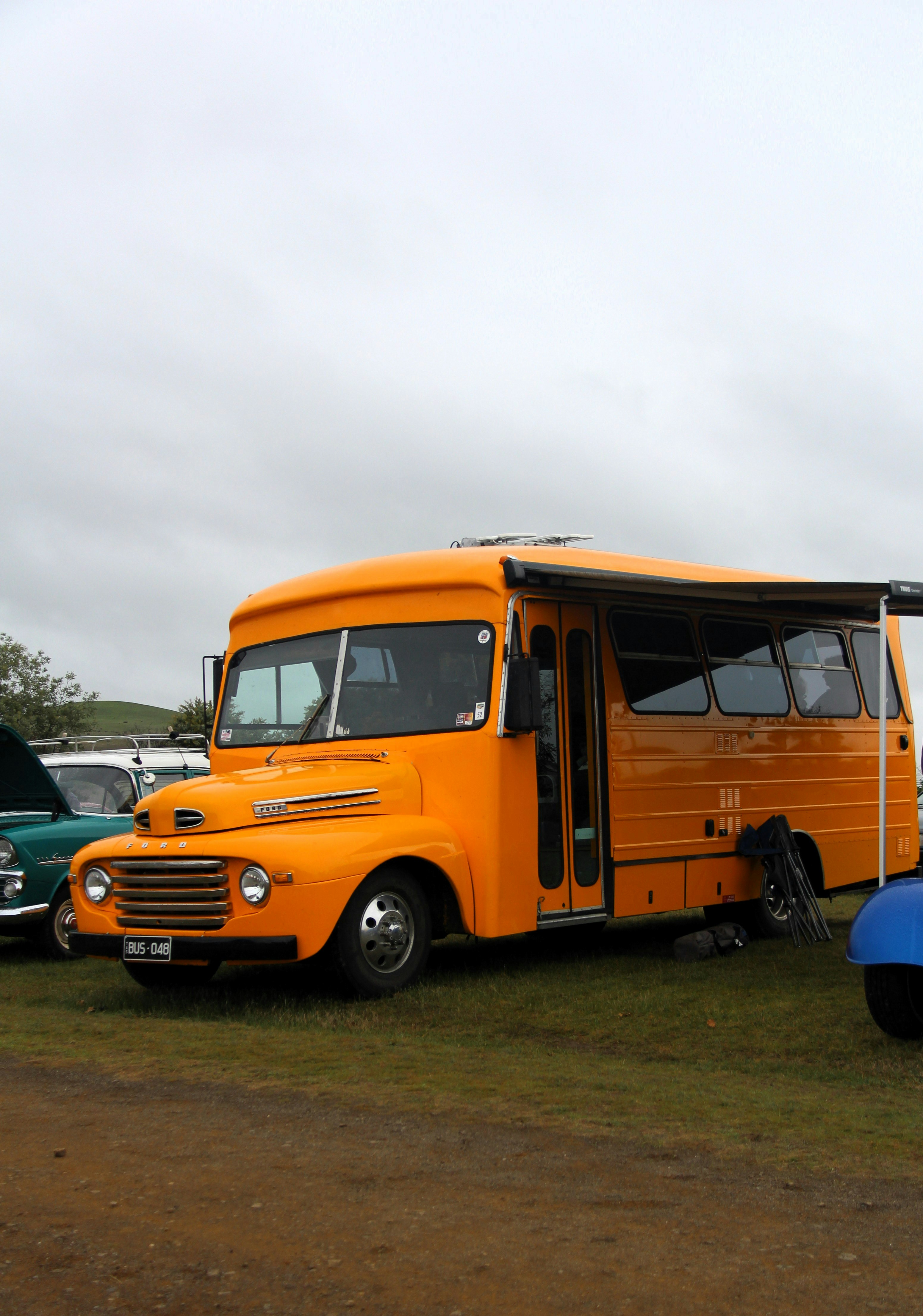 Orange Shuttle on a Quiet Field: A Retro Bus in Overcast Light