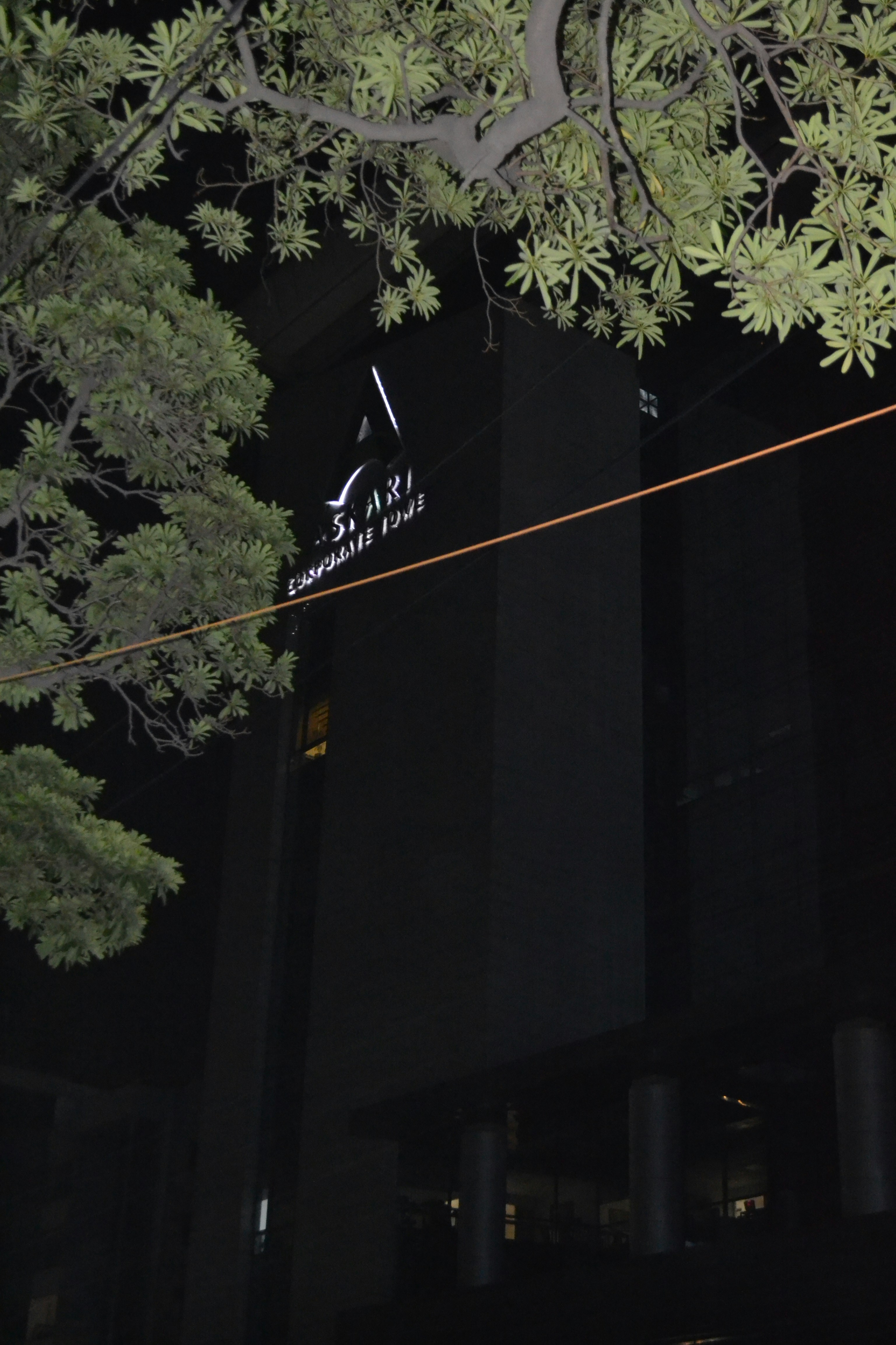 A tall building with a sign hanging off of it's side photo – Free ...