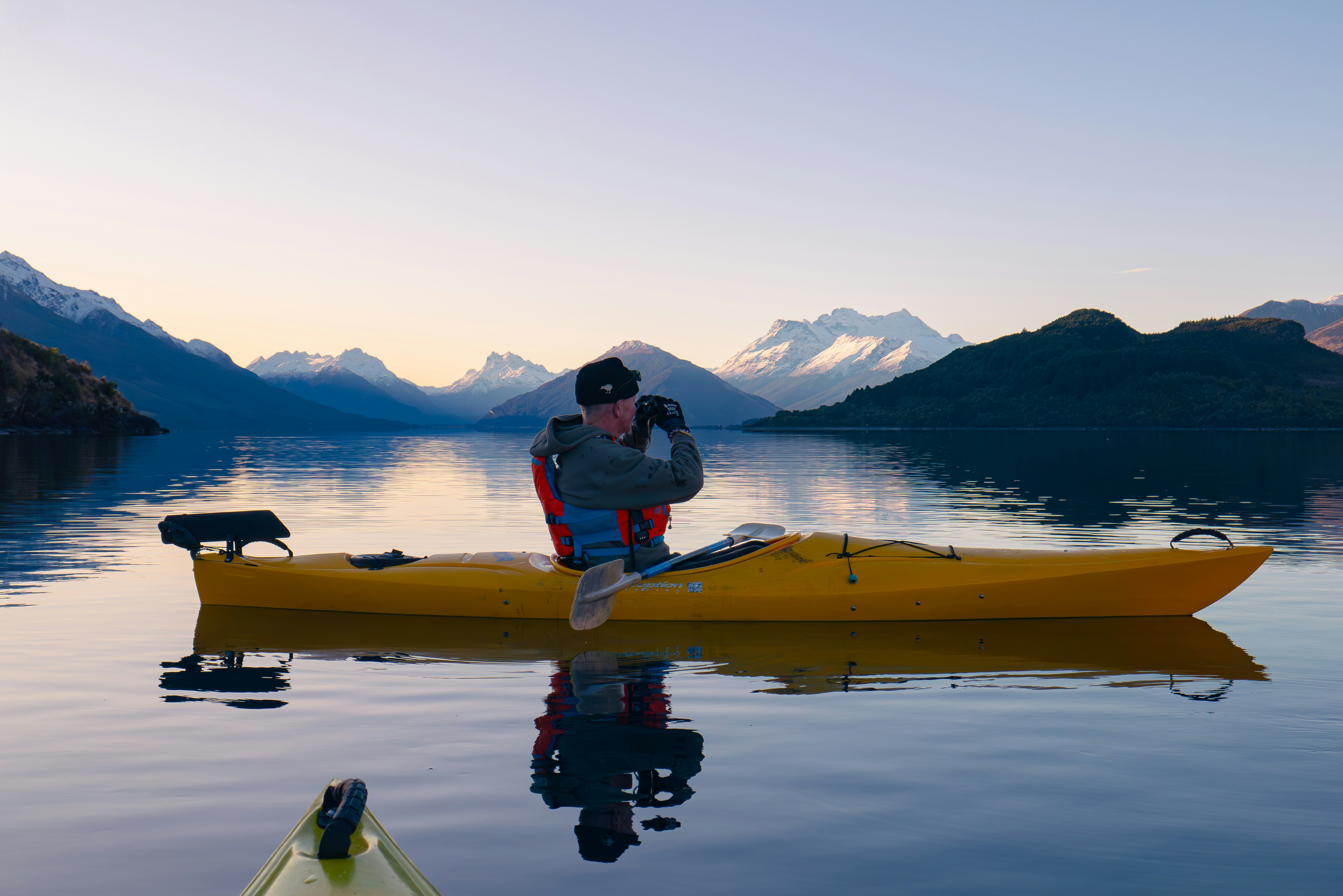 A man standing in a yellow kayak on a lake photo – Free Water Image on ...