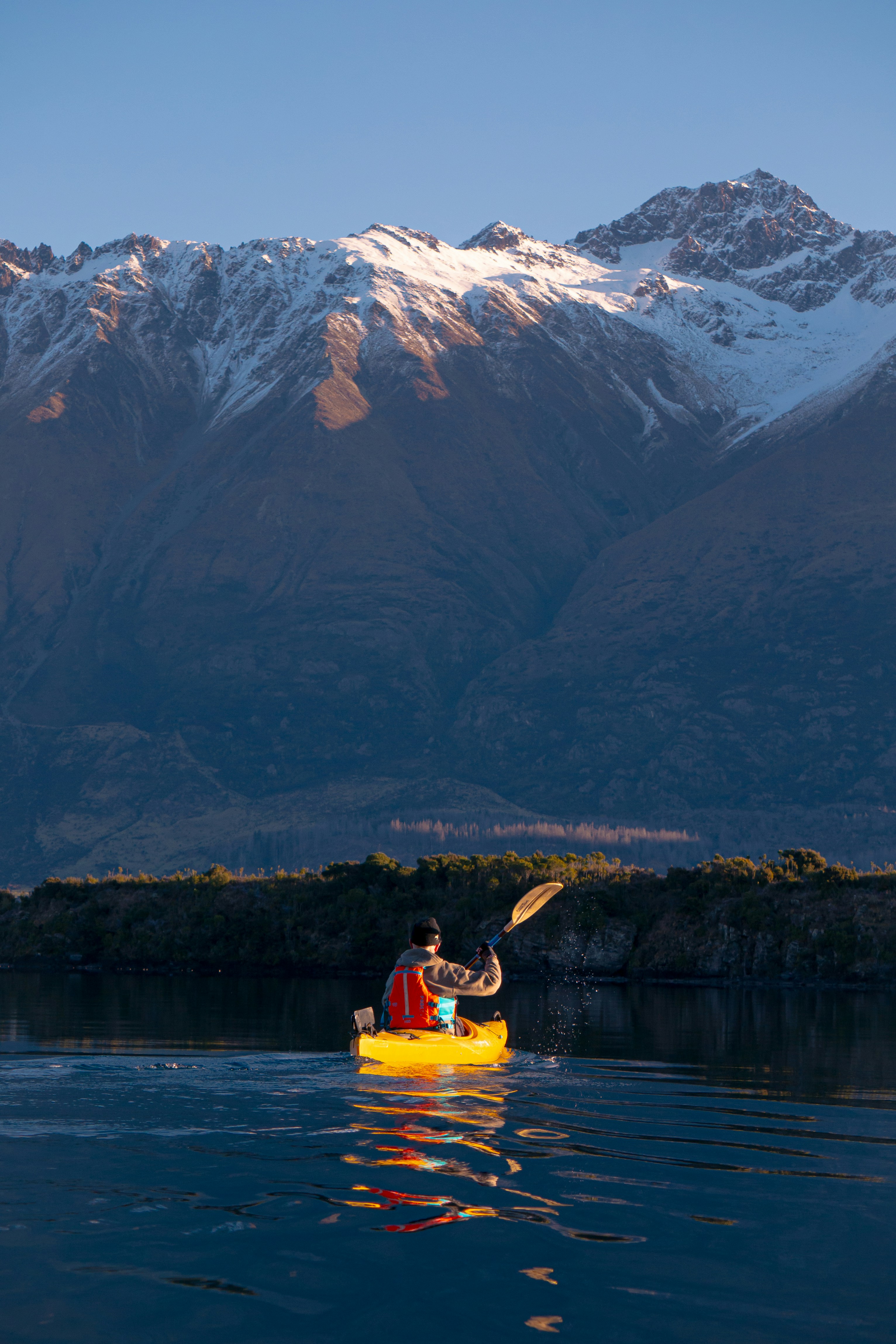 Yellow Kayak on a Glassy Lake Beneath Snow-Capped Peaks