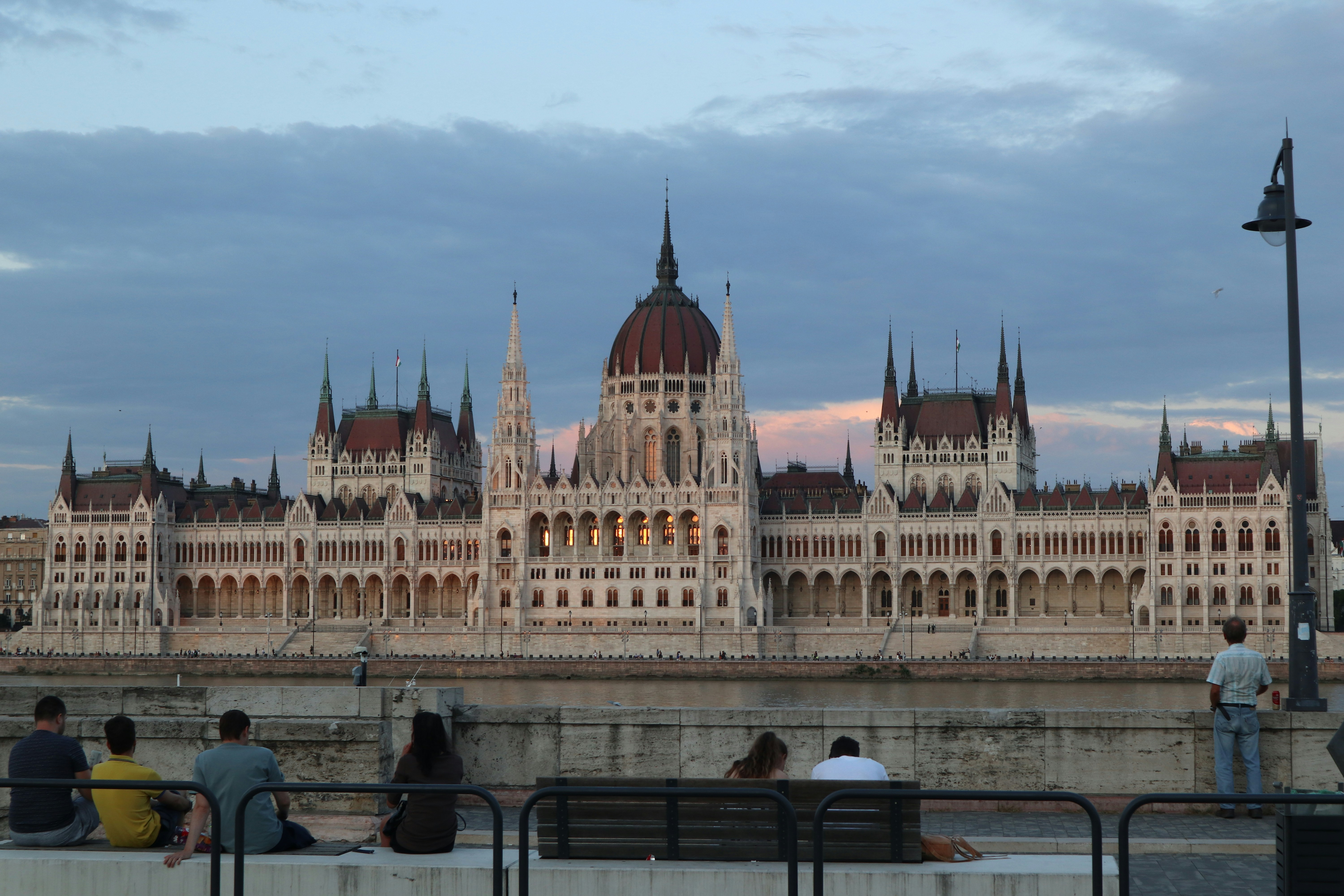 Budapest Parliament by the Danube: evening silhouettes and riverside spectators