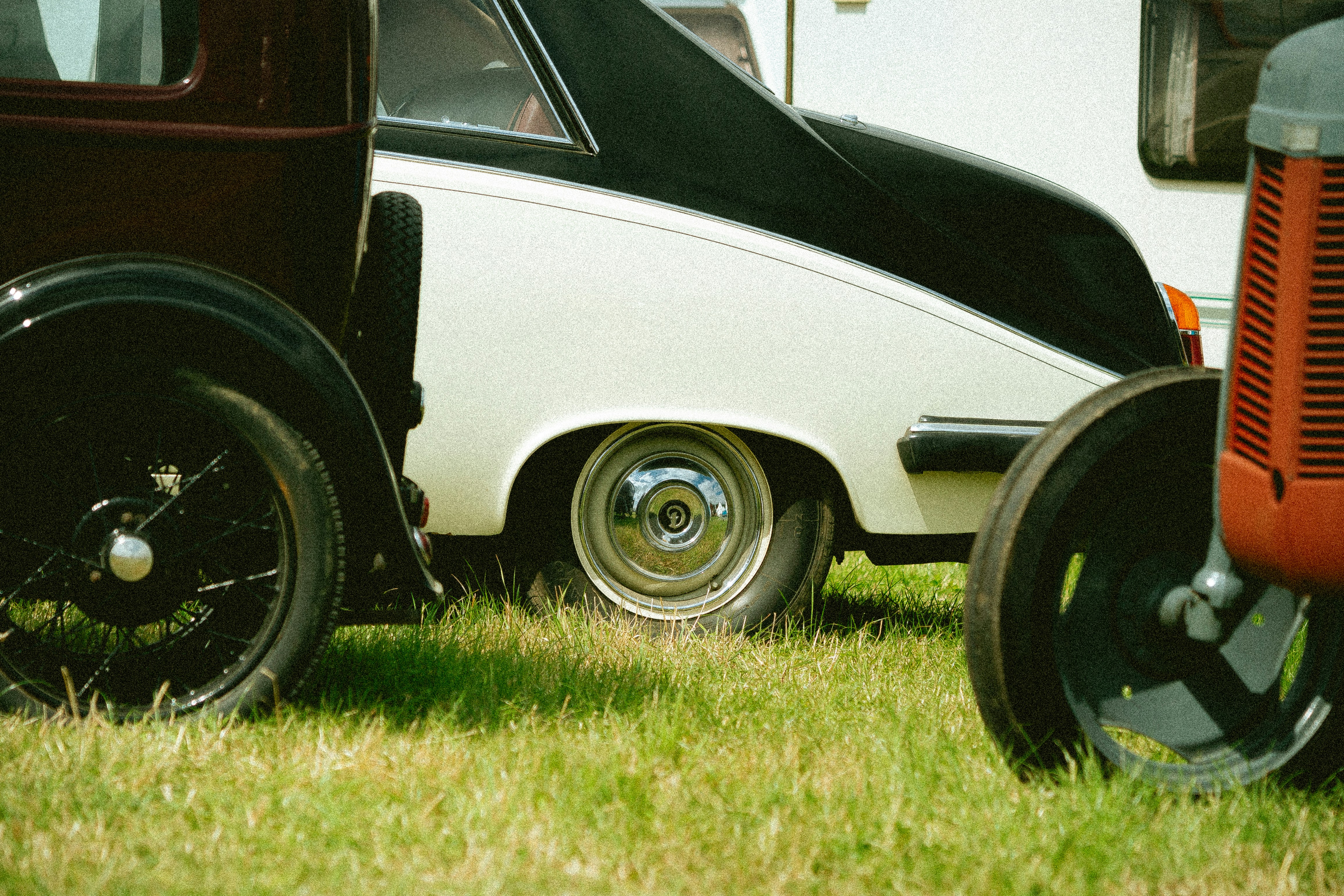 Center Wheel Reverie: A Quiet Vintage Car Moment in the Grass