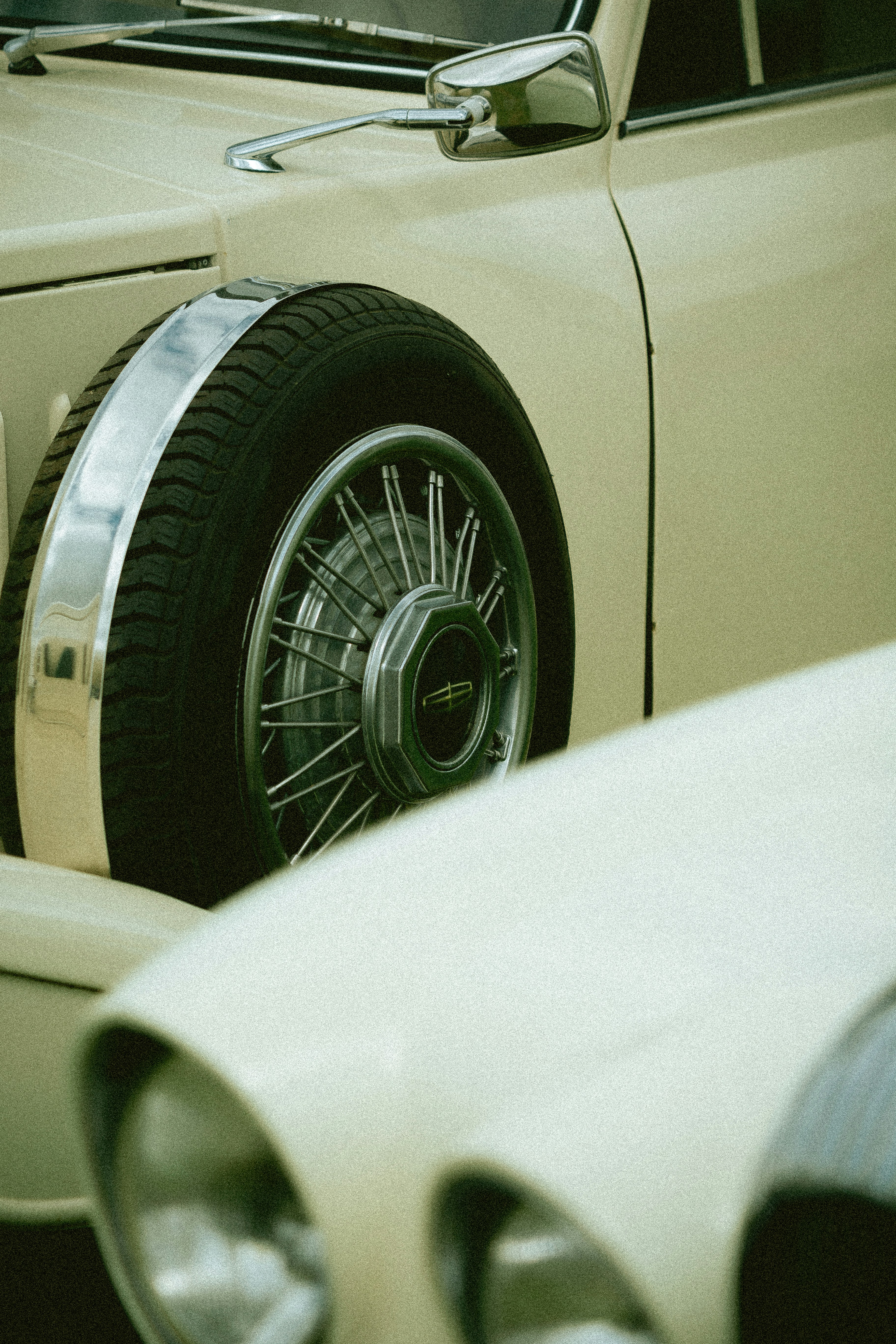 Beige Classic: Close-up on a vintage car wheel and chrome trim