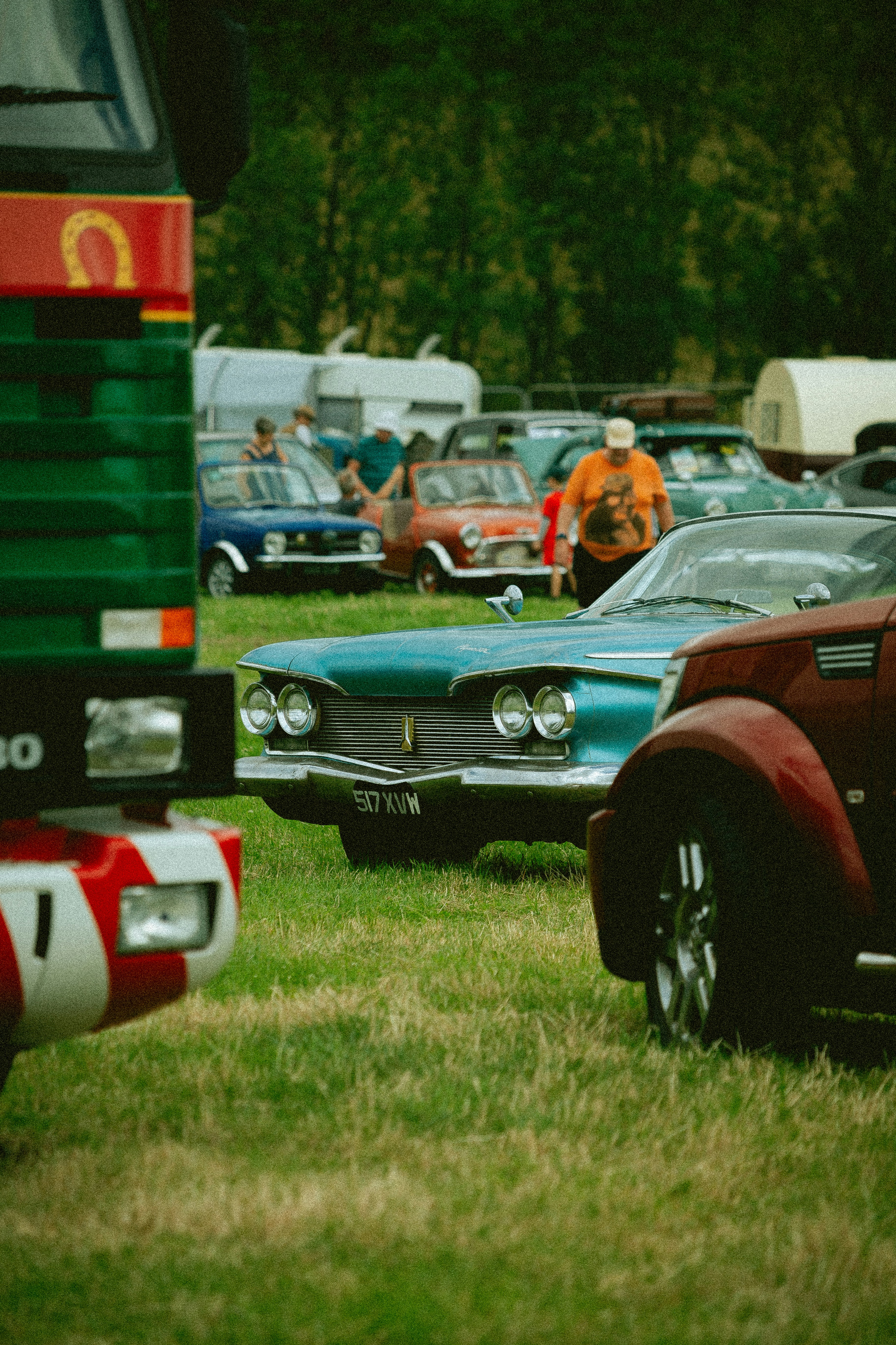Teal Classic in the Grass: A Midfield Parade of Vintage Cars