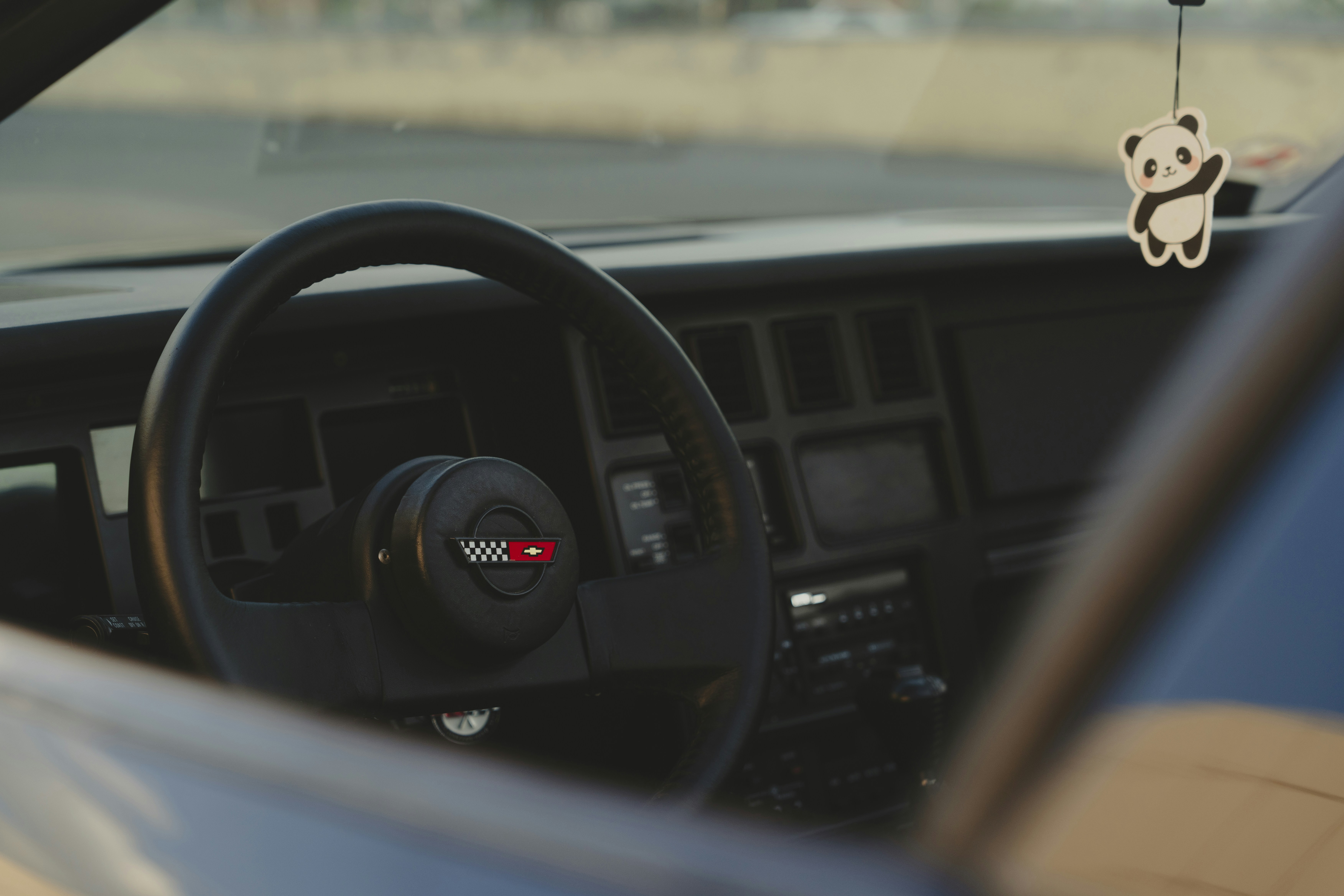 Center-Stage in the Quiet Cockpit: a vintage steering wheel and panda charm