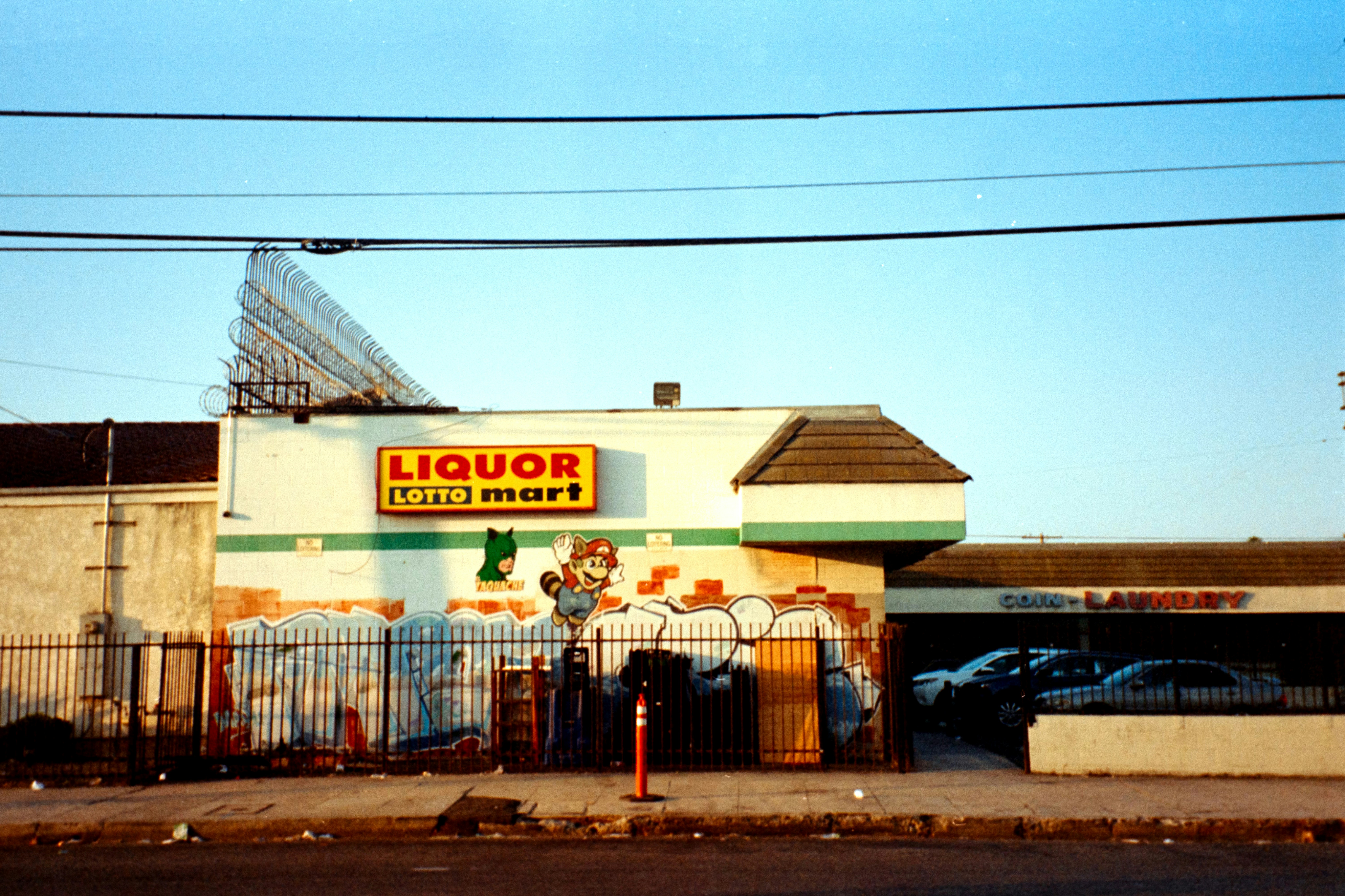 A liquor store with graffiti on the side of it photo – Free Usa Image ...