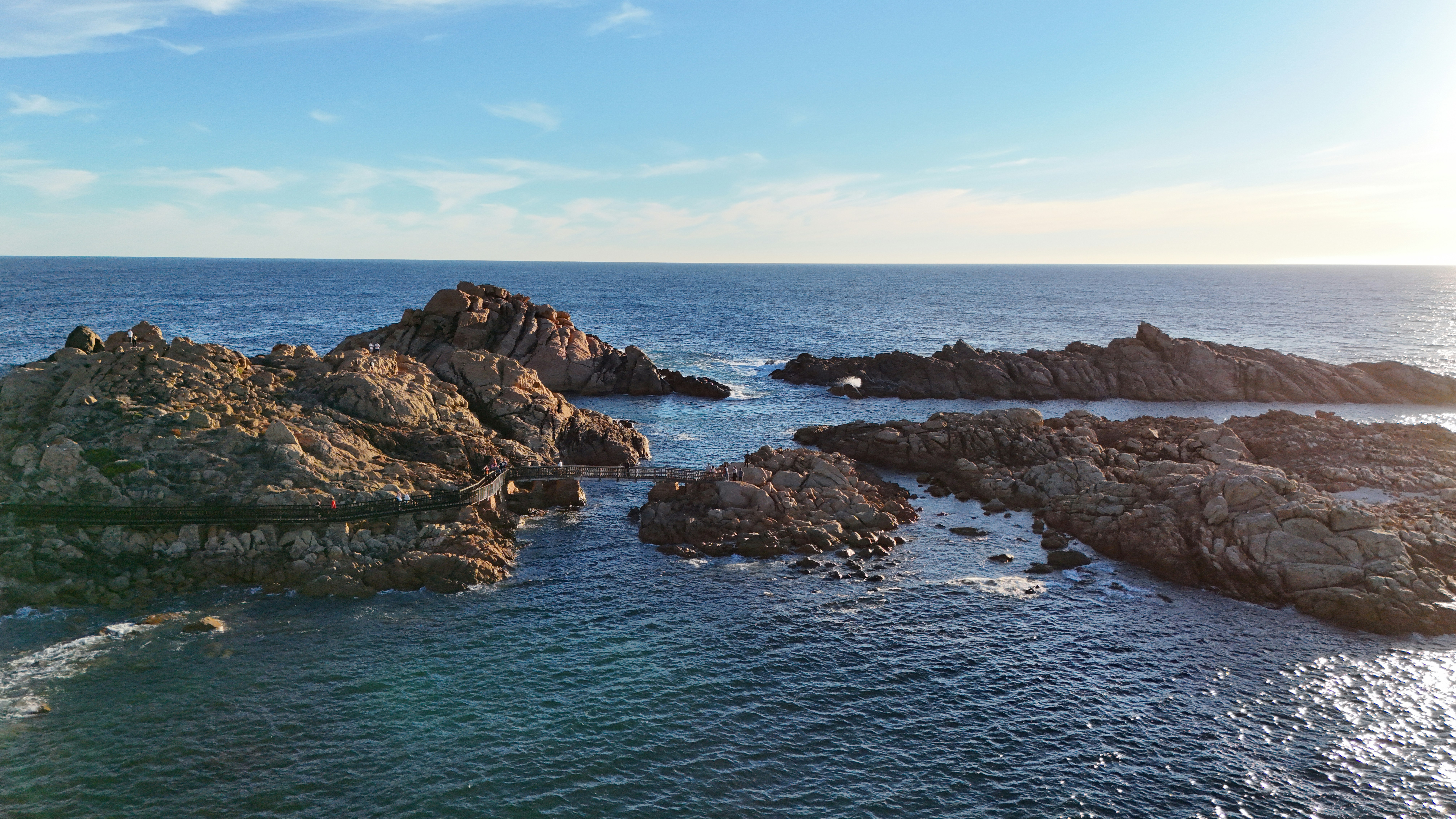 An aerial view of the ocean with rocks in the foreground photo – Free ...