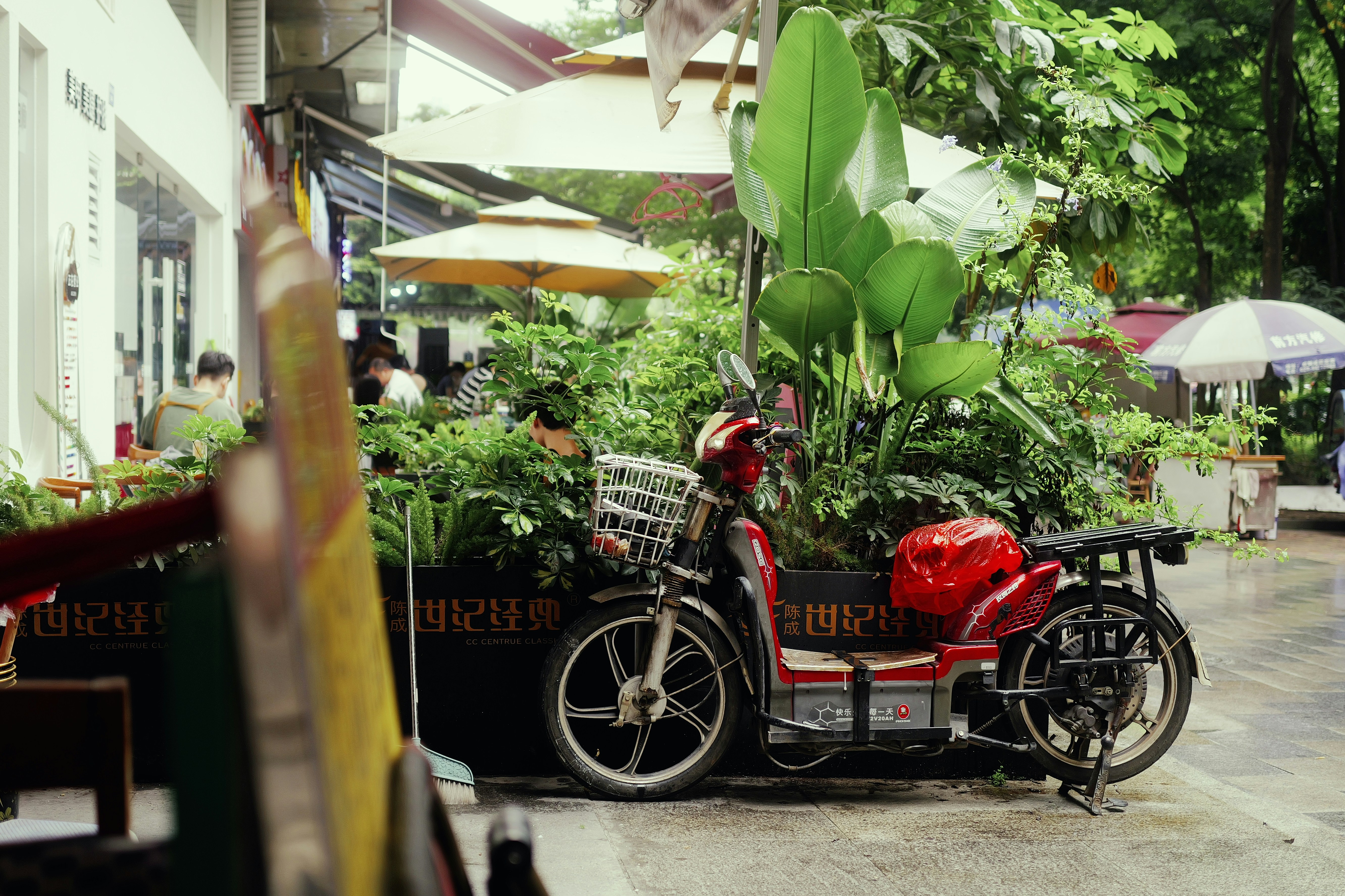 Red Scooter in a Sunlit Café Alley