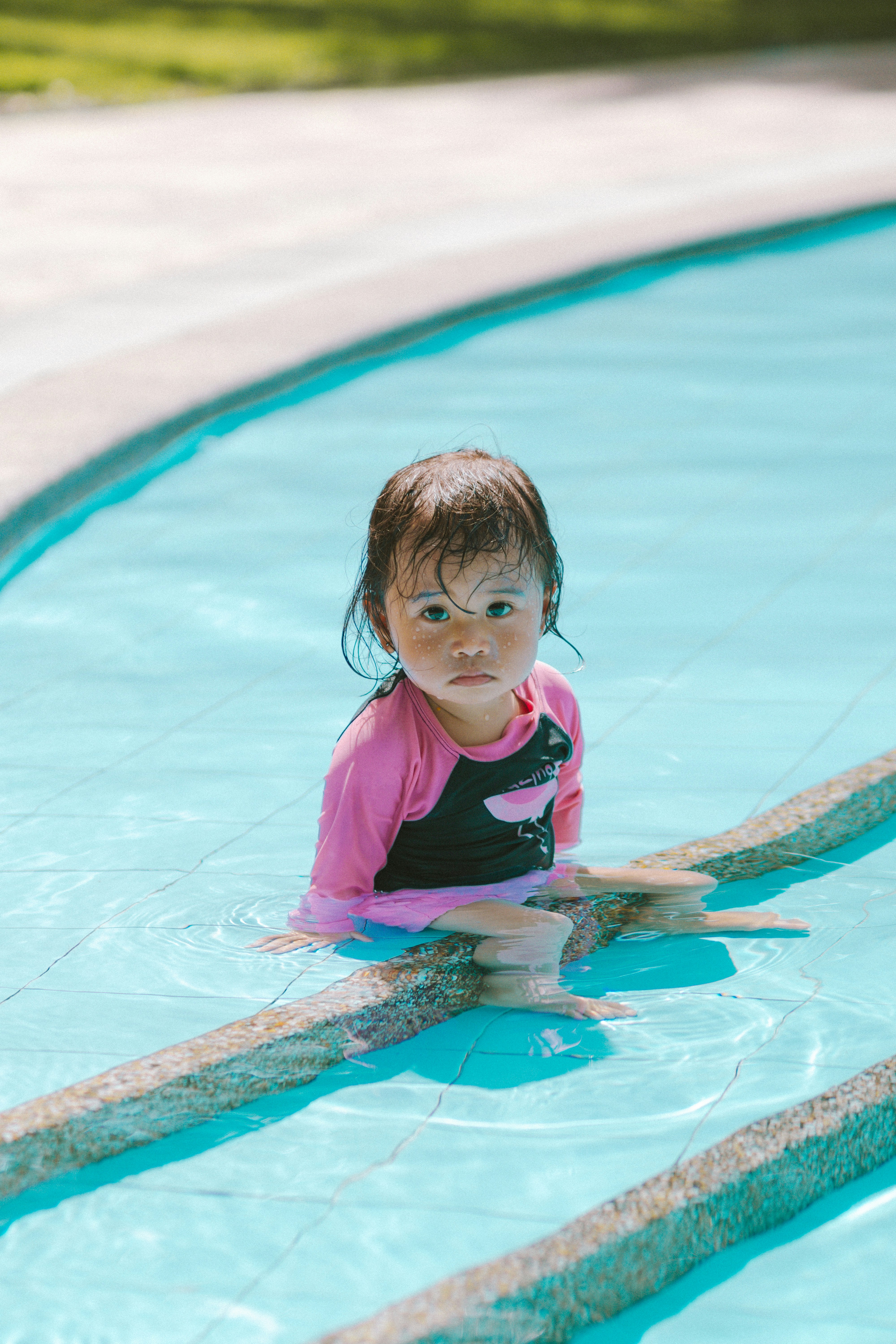 A little girl in a pink shirt is in a pool photo – Free Portrait Image ...