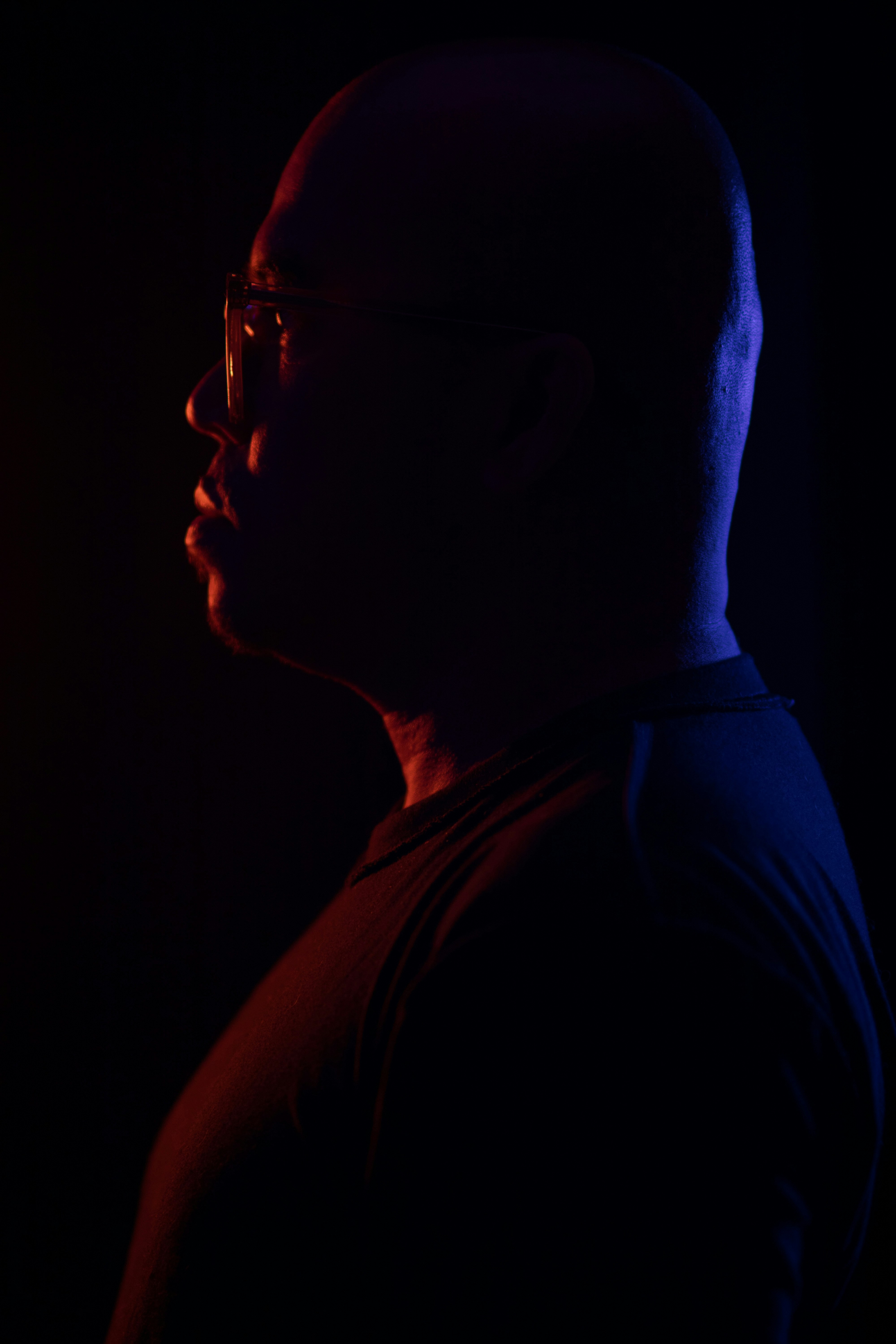 A man standing in the dark with a red light behind him photo – Free ...