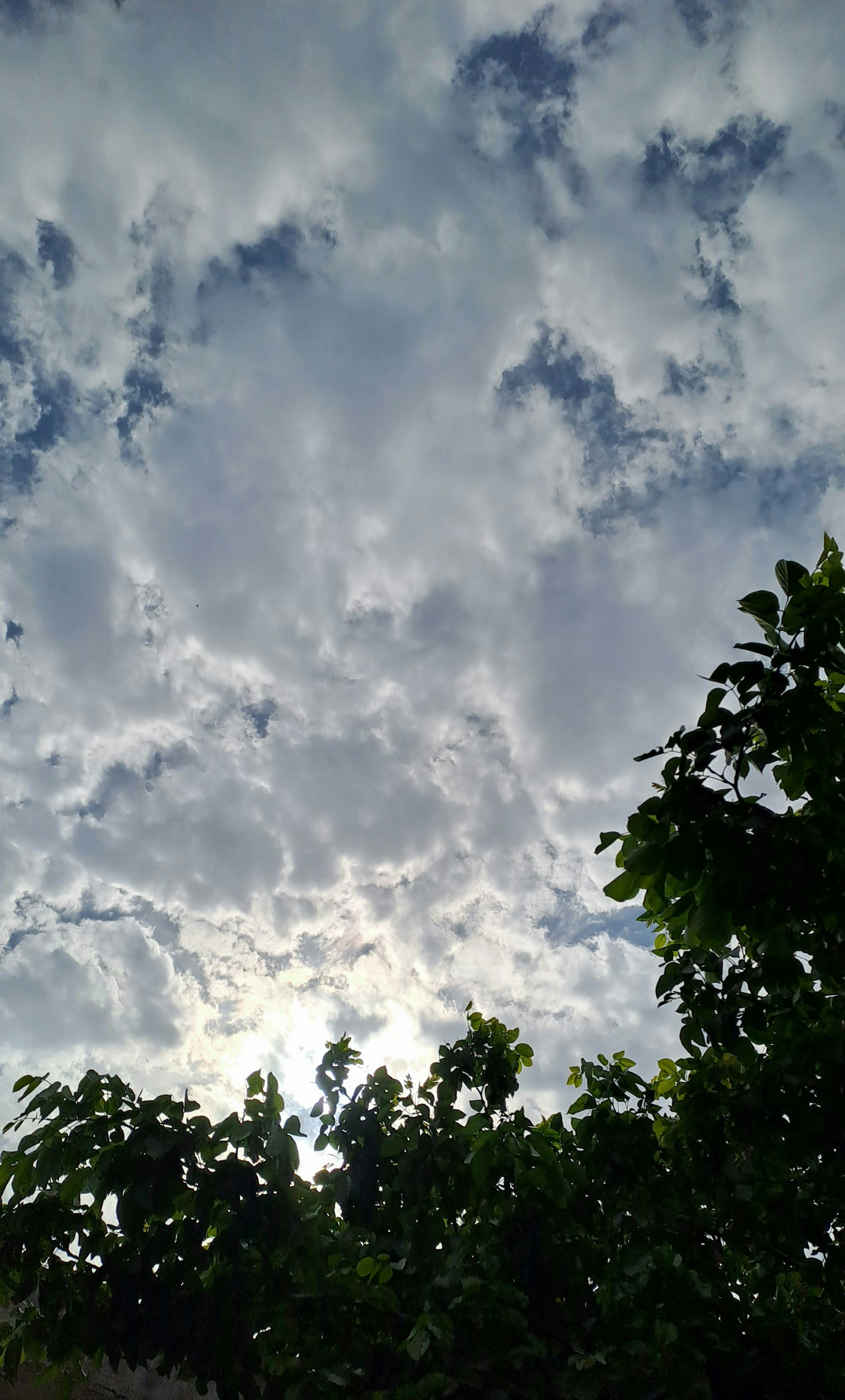 The sun is shining through the clouds in the sky