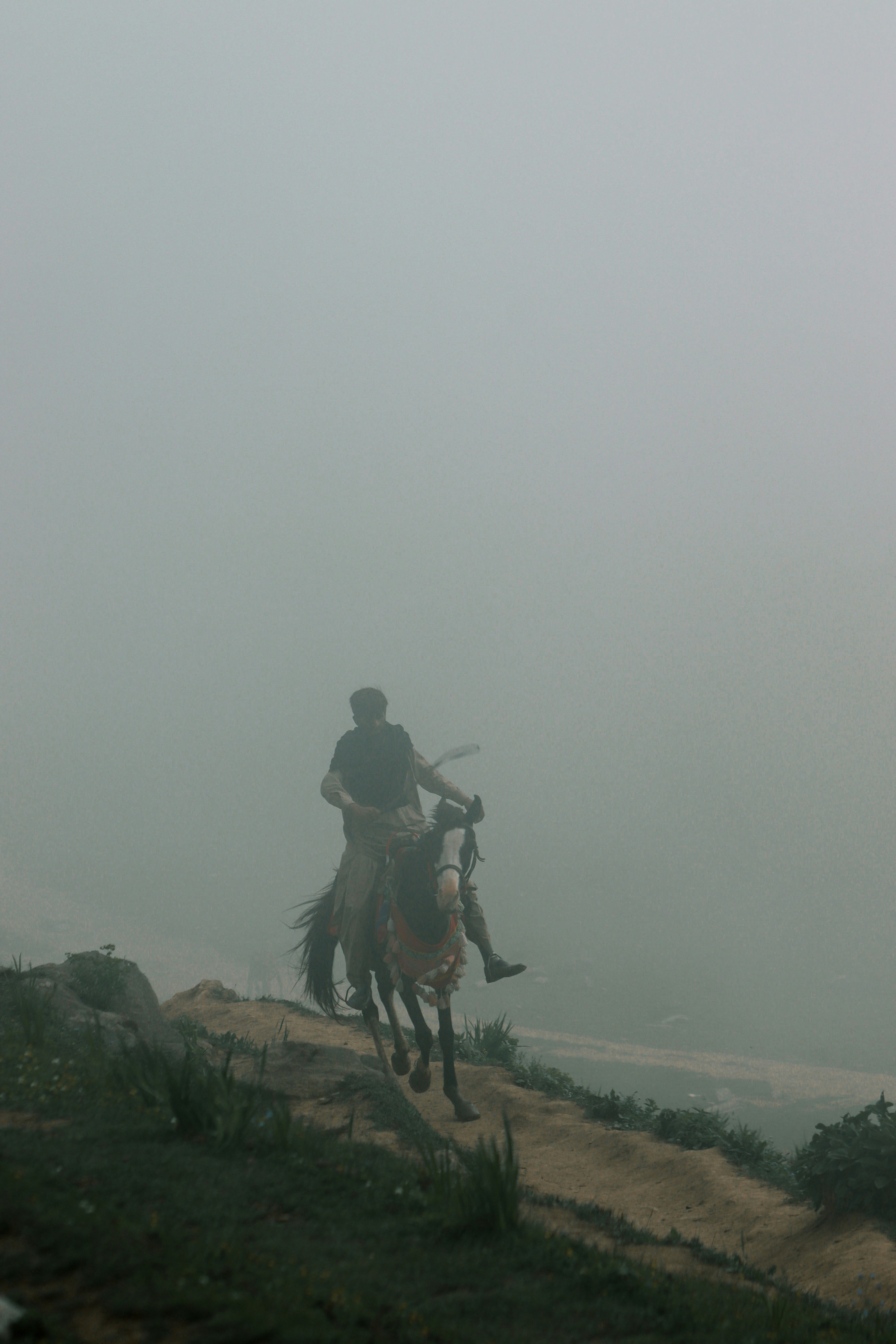 Mistbound Riders on a Foggy Cliff Trail